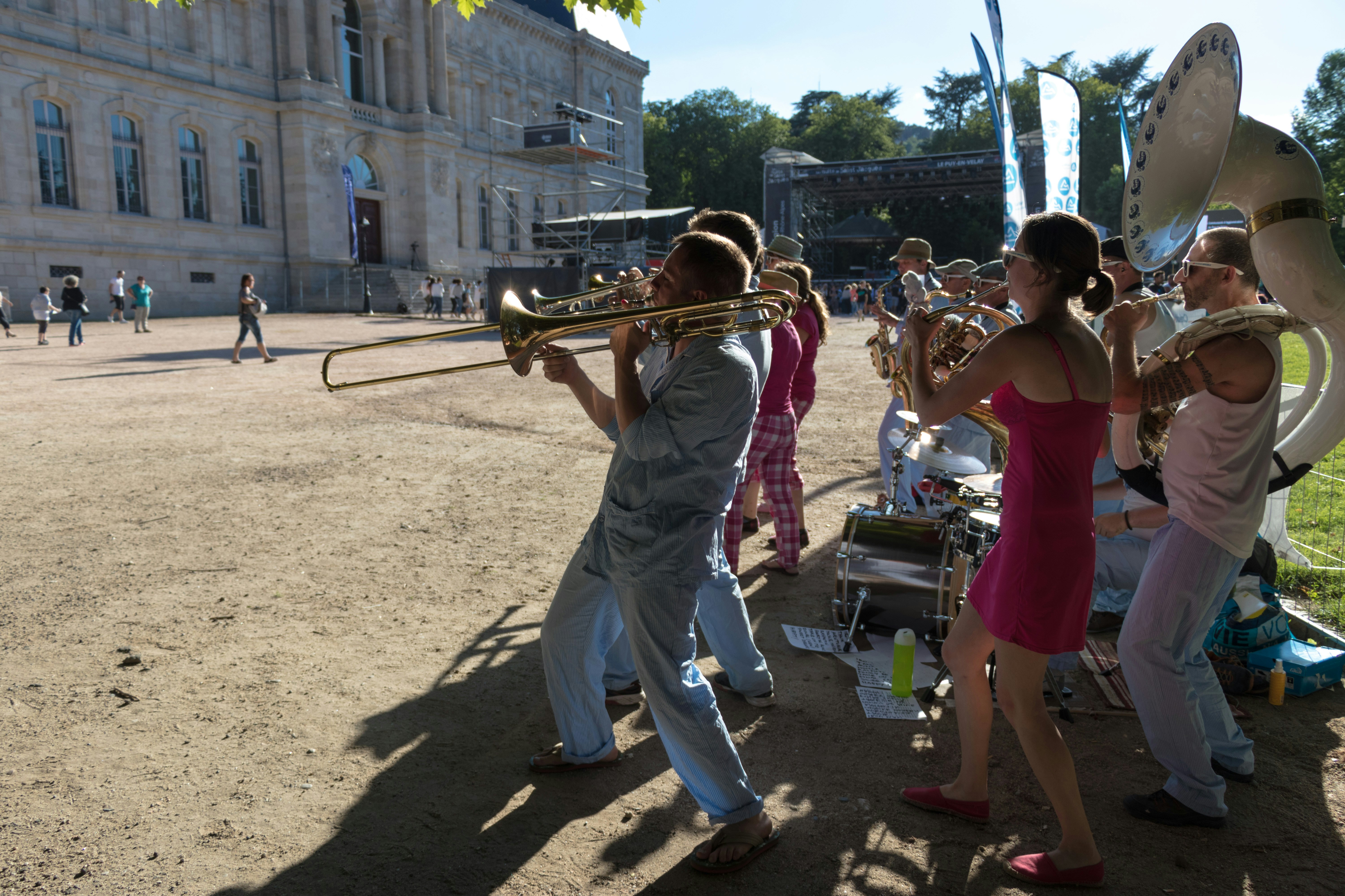 A group of people playing instruments in front of a building photo ...