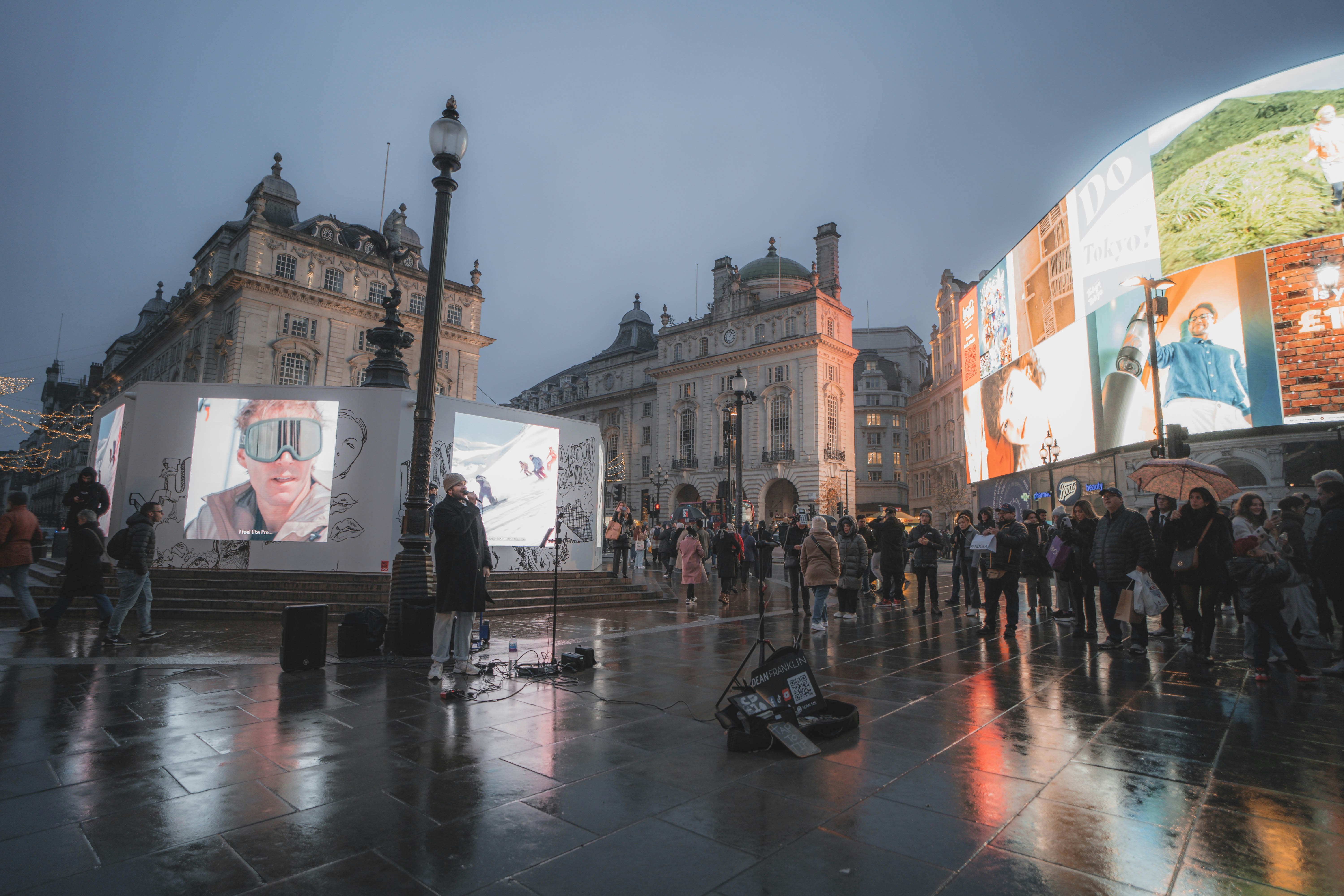 A group of people standing around a movie screen photo – Free Building ...