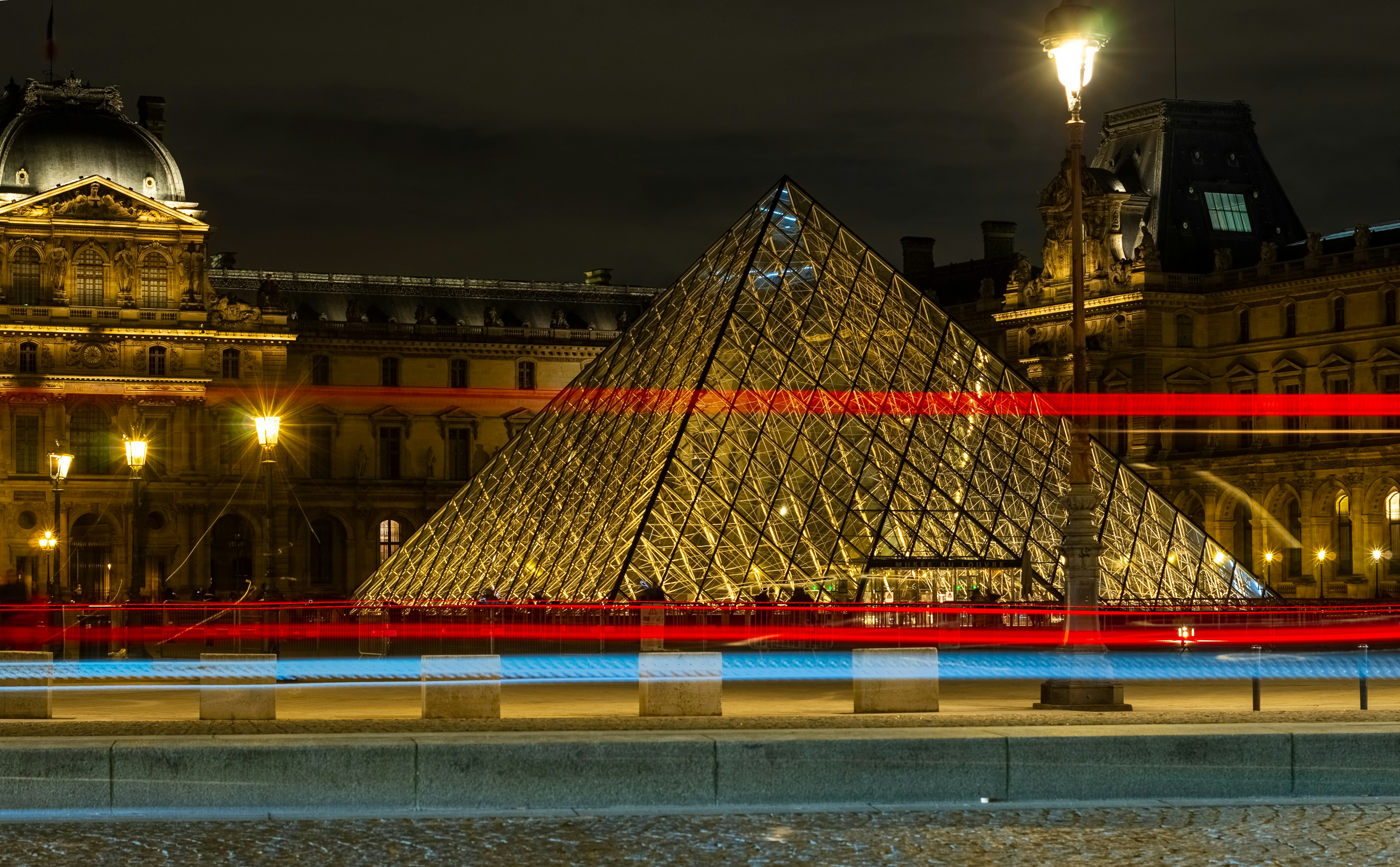 A long exposure photo of a building with a pyramid in front of it photo ...