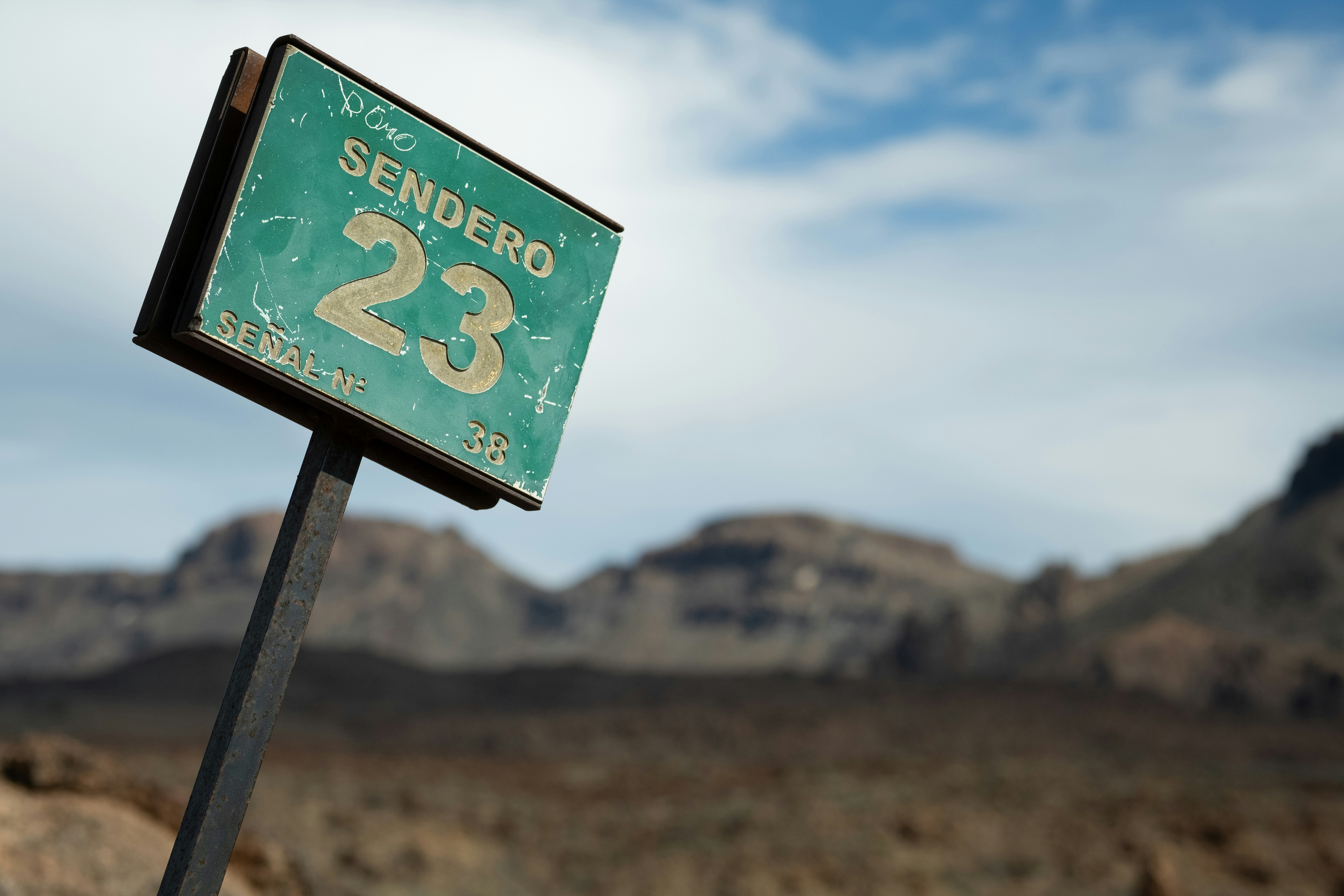 Weathered Sendero 23 Sign Leaning Into a Quiet Desertscape