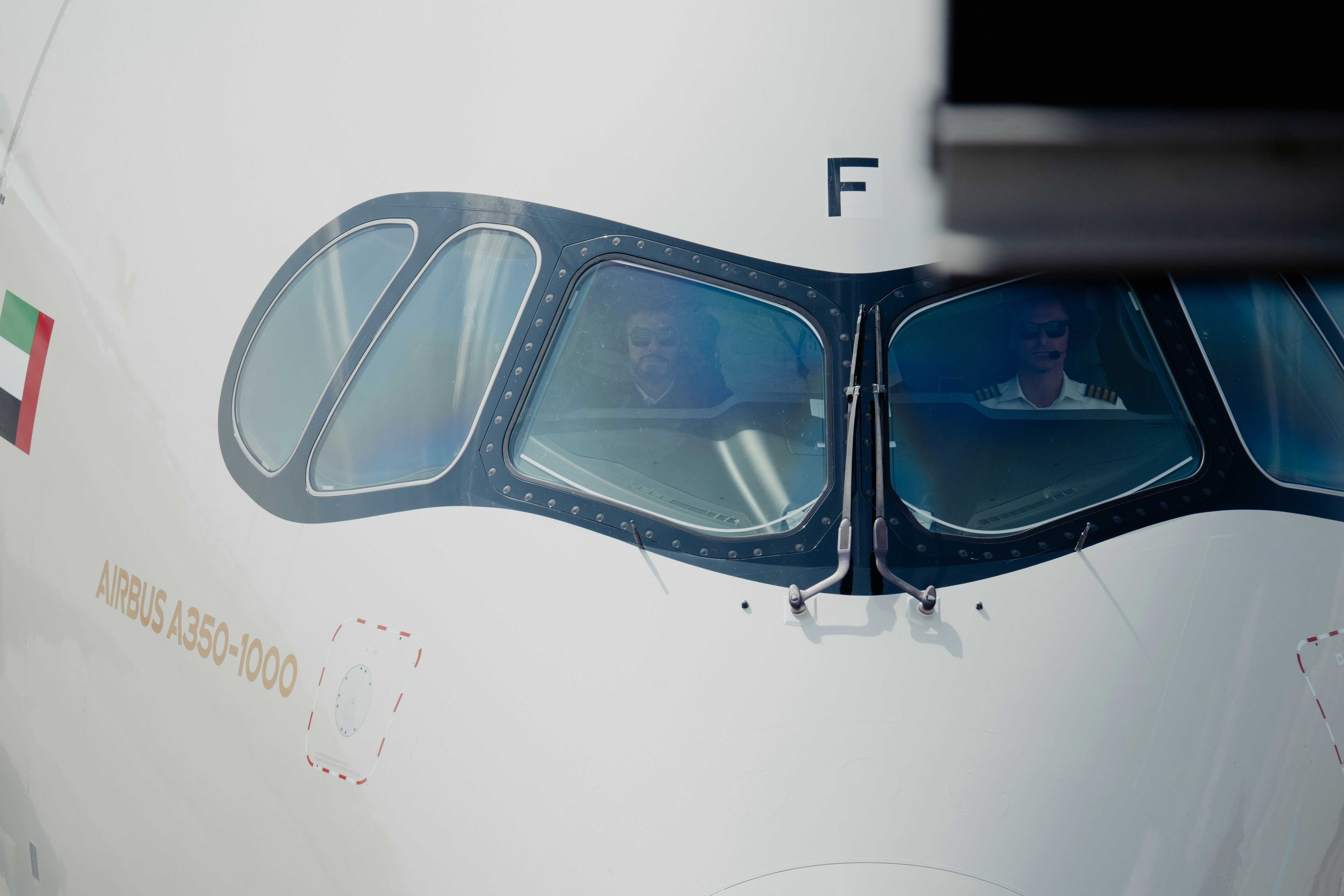 Cockpit Glass: A Close-Up of the Airbus A350-1000 Nose Window with Pilots Peering In