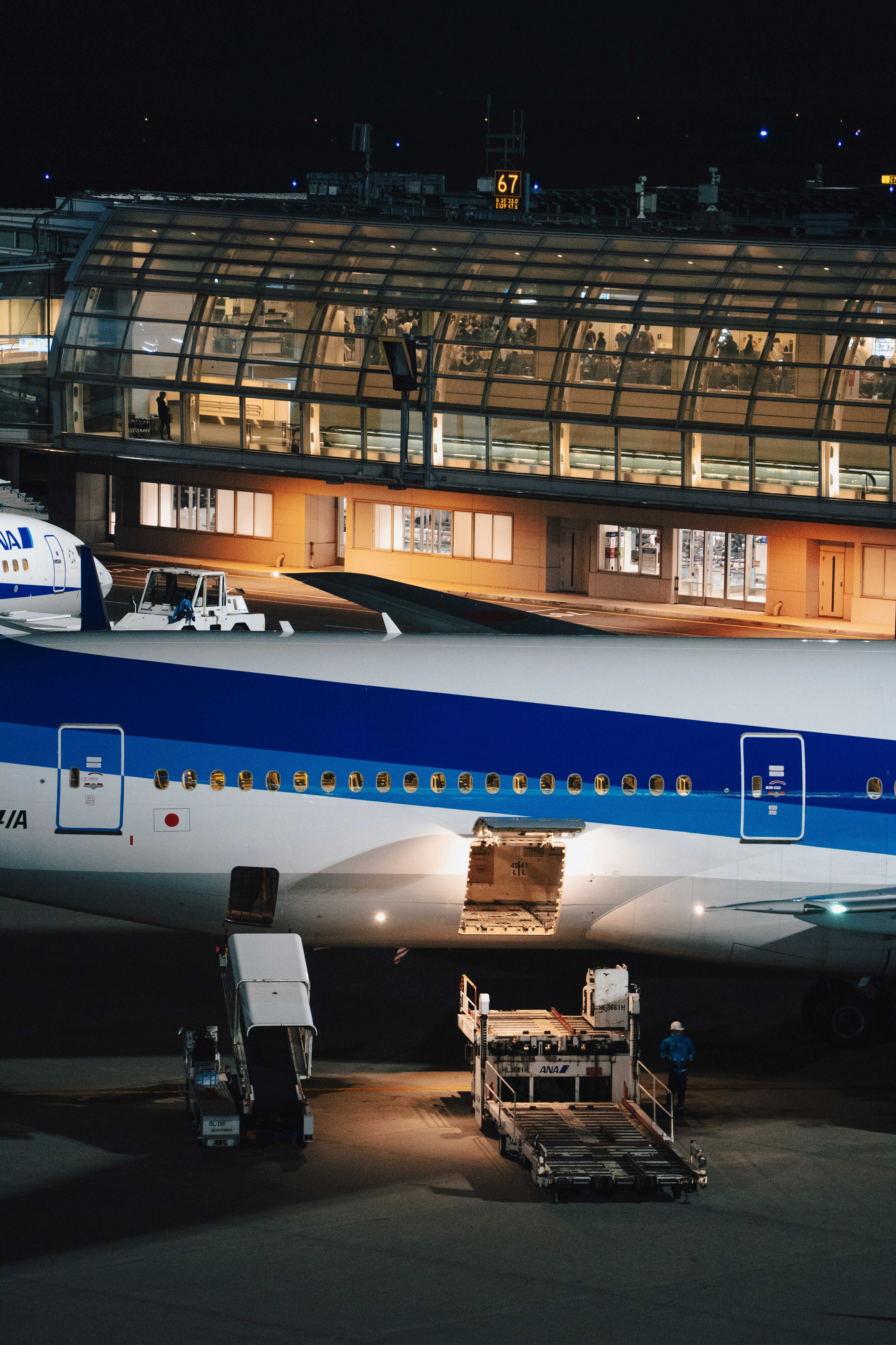 Blue Liner Under Glass Canopy: Night Gate Scene with a Parked Jet