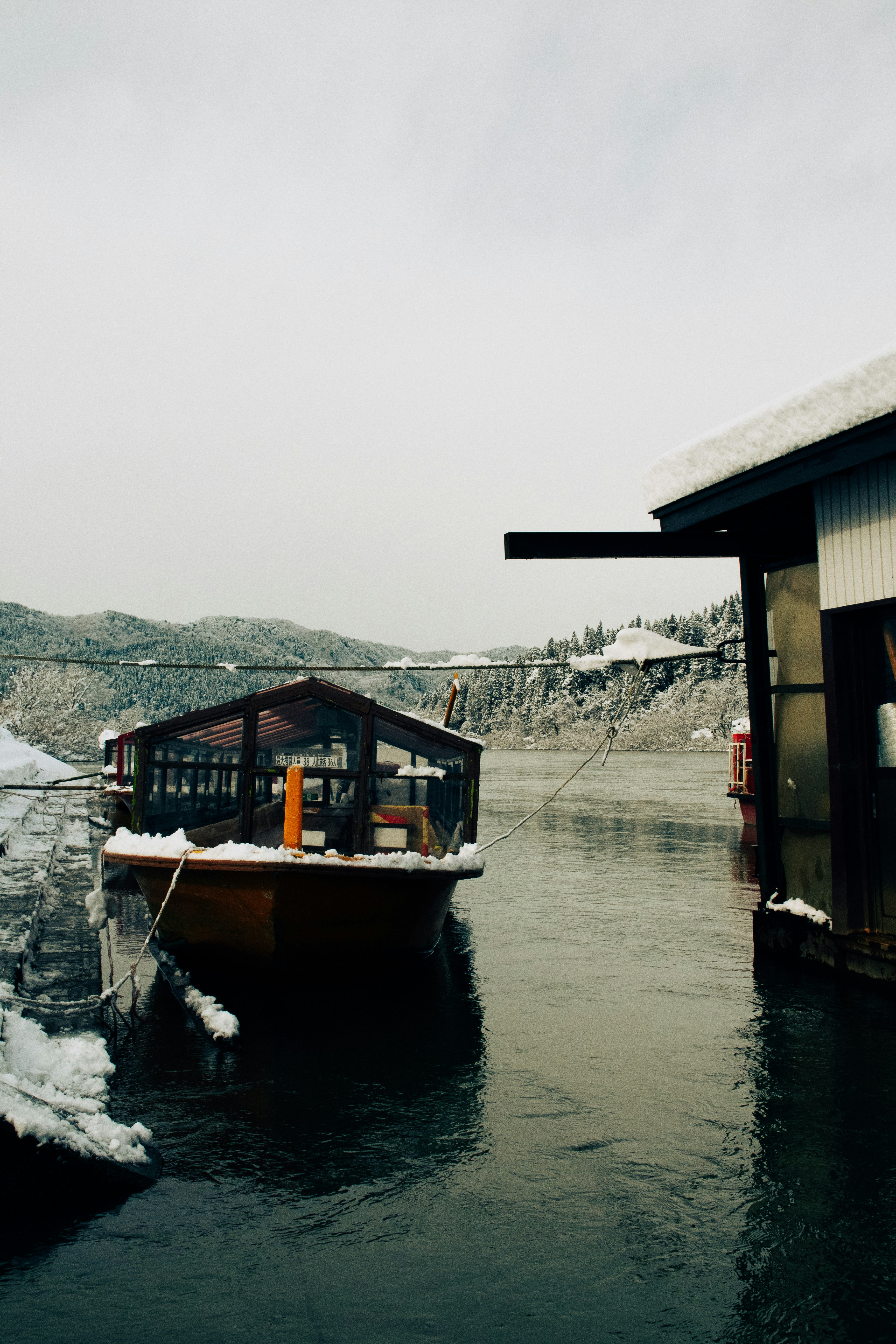 Frostbound Quay: A Snow-Dusted Boat by the Silent Boathouse