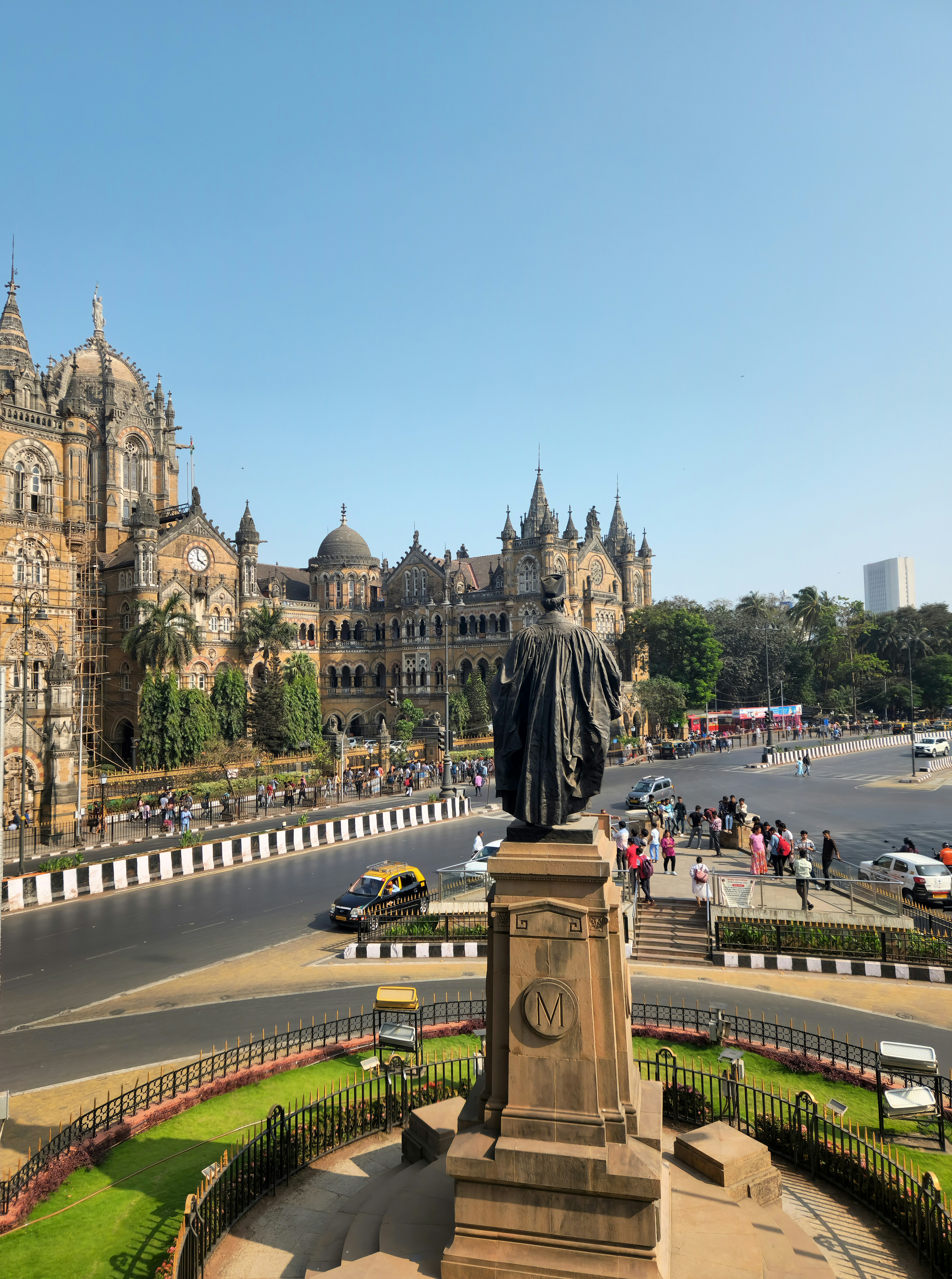 Bronze Guardian Framing a Sunlit Gothic Campus in Mumbai