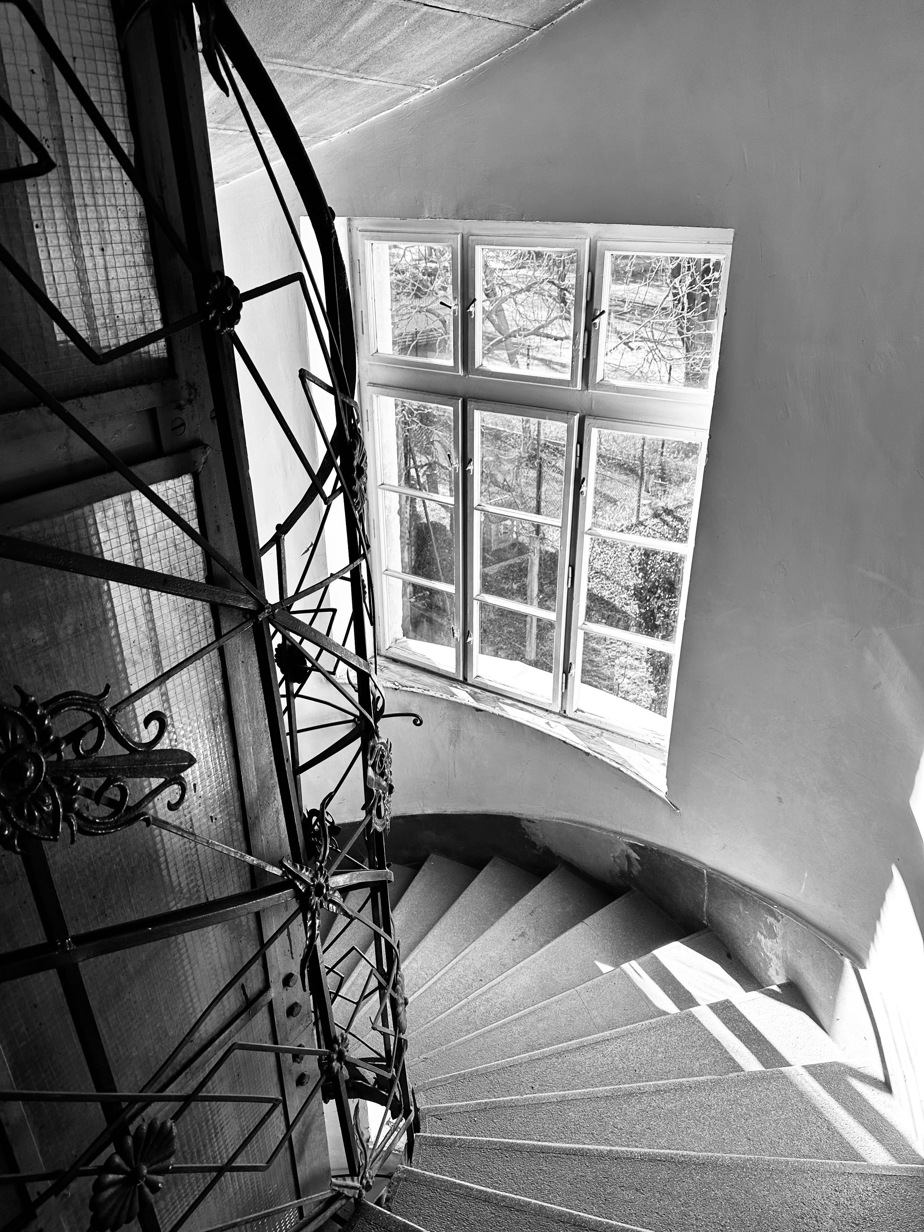 A spiral staircase leading to a window in a house photo – Free Building ...