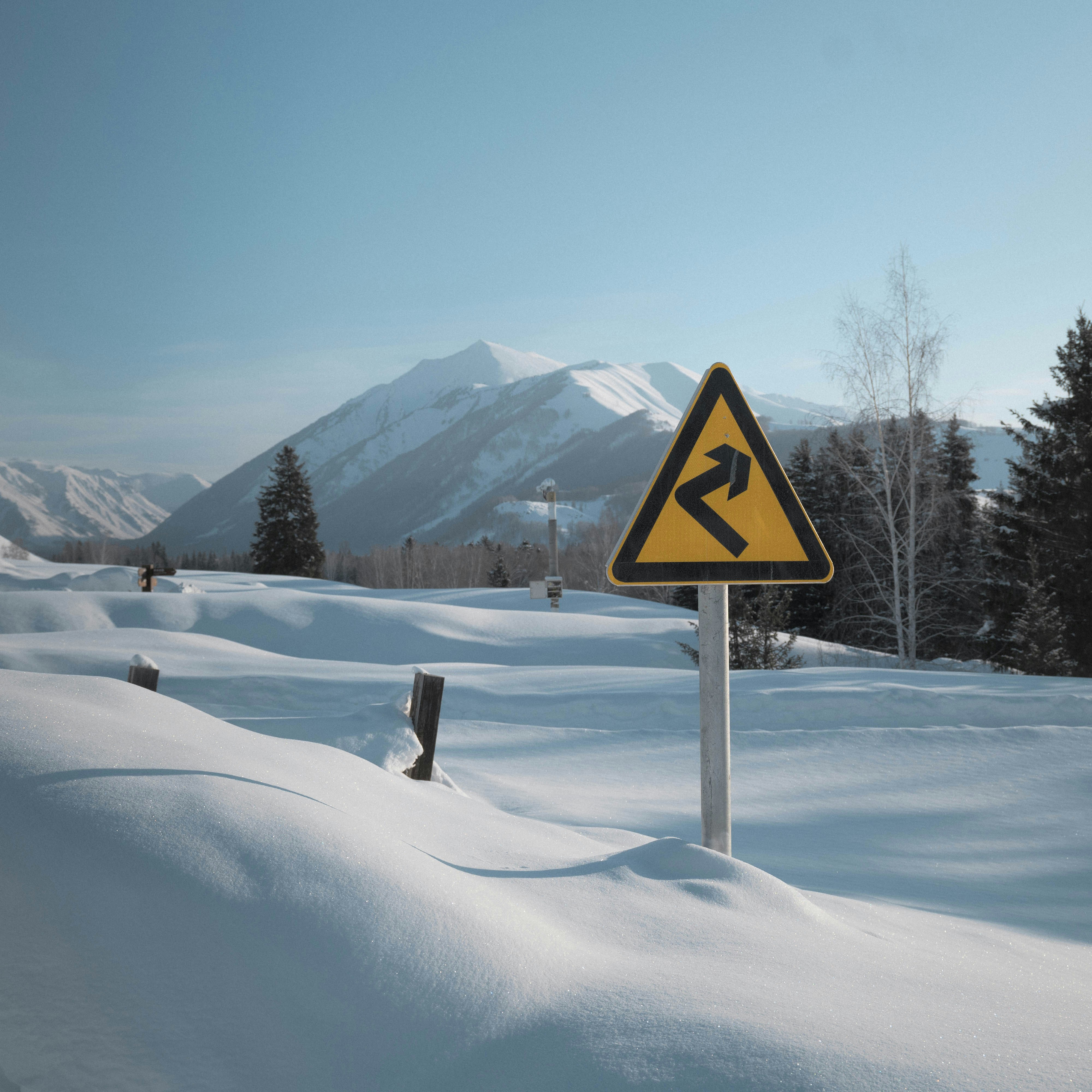 Snowbound Curve: A Winding Warning Banner in the Mountain Quiet