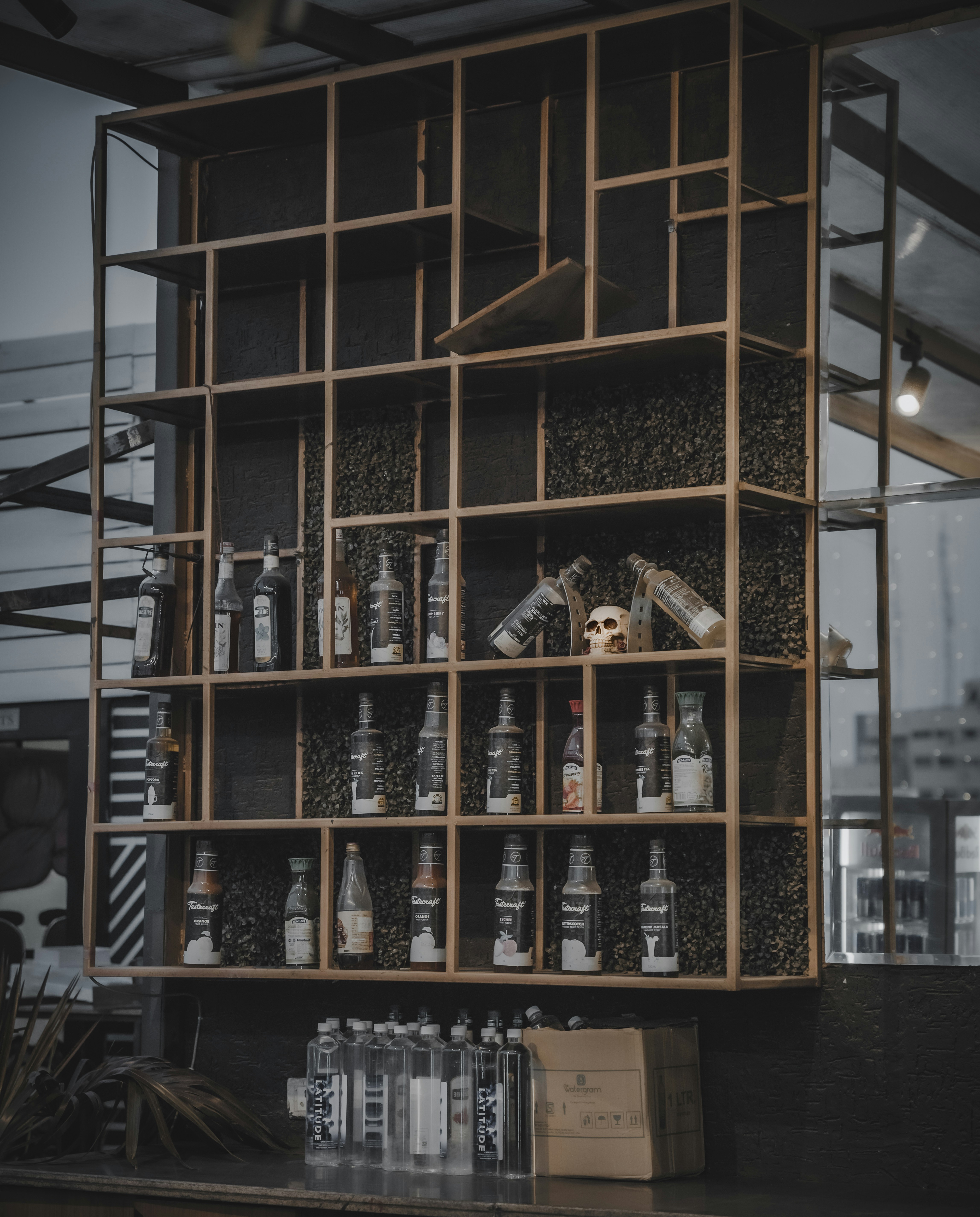 Skeleton of Spirits: Bottles on a Dim Bar Shelf