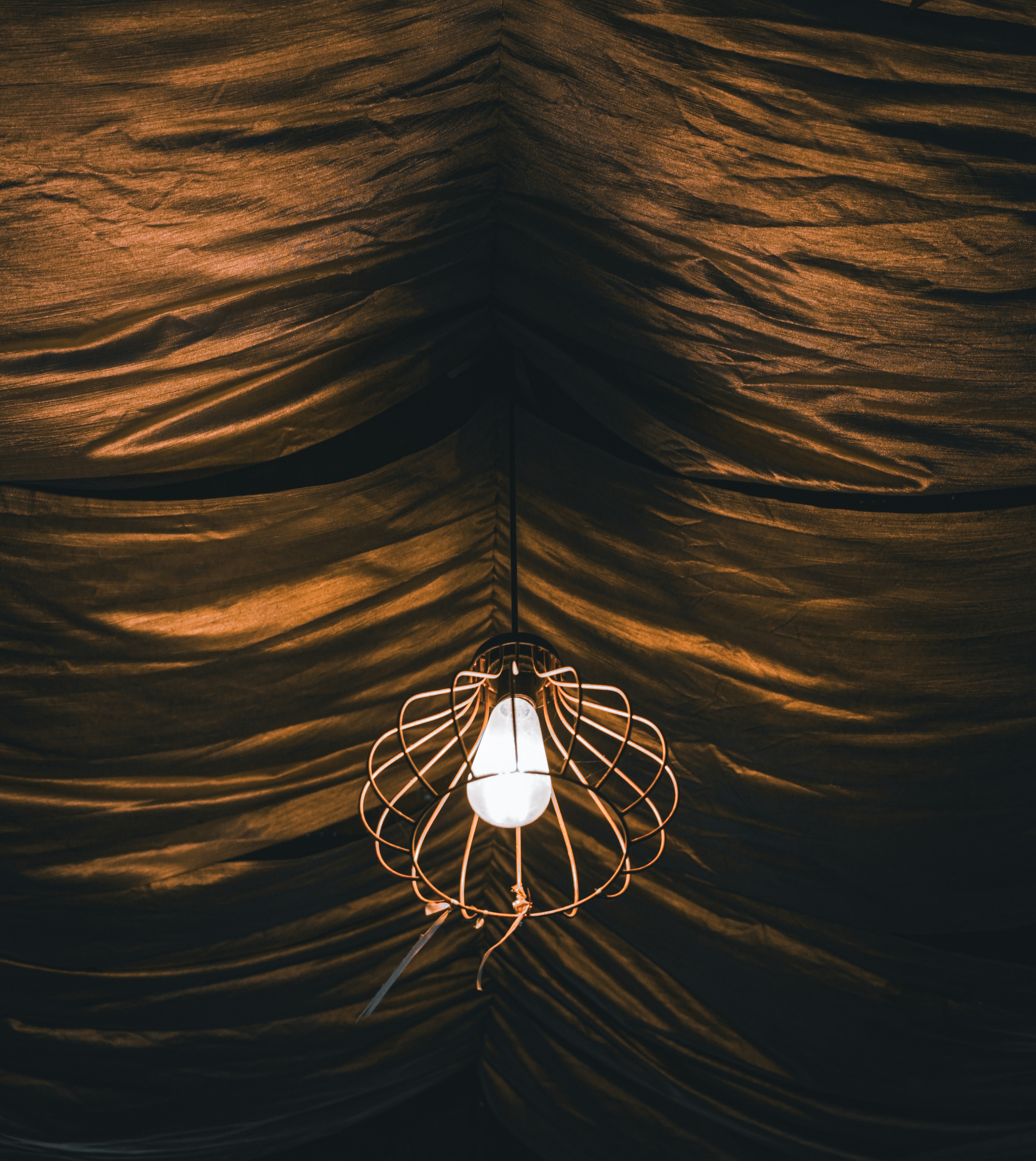 Copper Cage Lantern Softly Glows Beneath Velvet Pleats