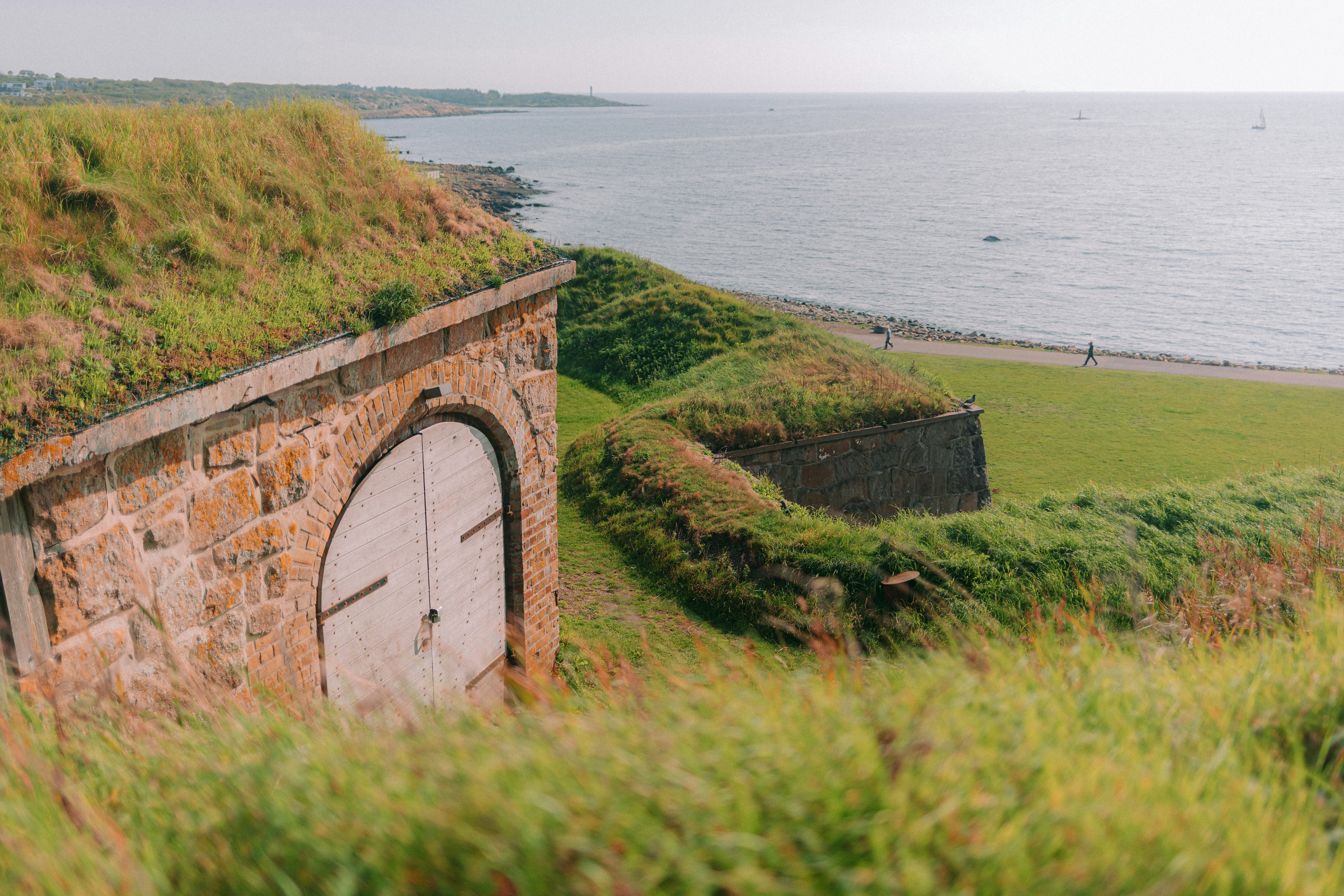 The Gate by the Tide: A Weathered Stone Arch Over a Green Cliff