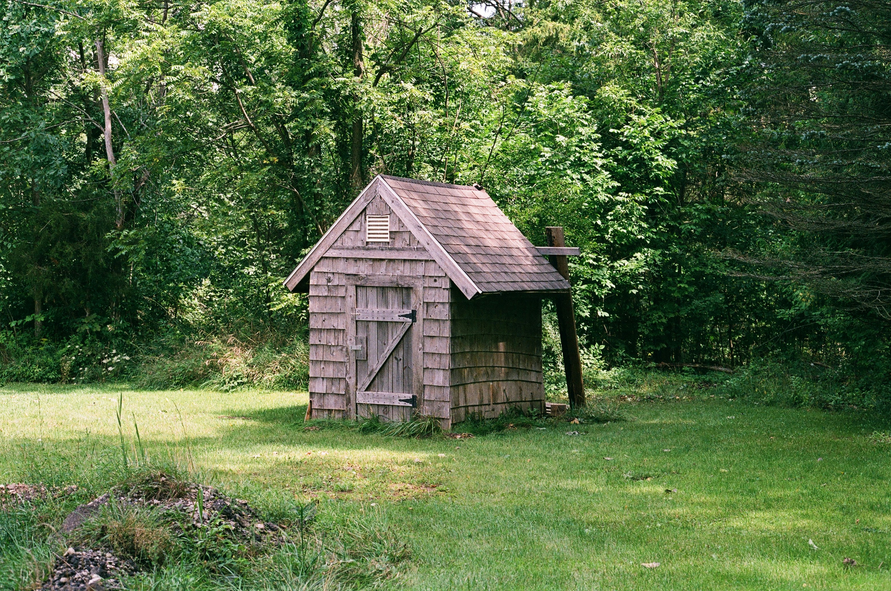 A small wooden outhouse in the middle of a field photo – Free Michigan ...
