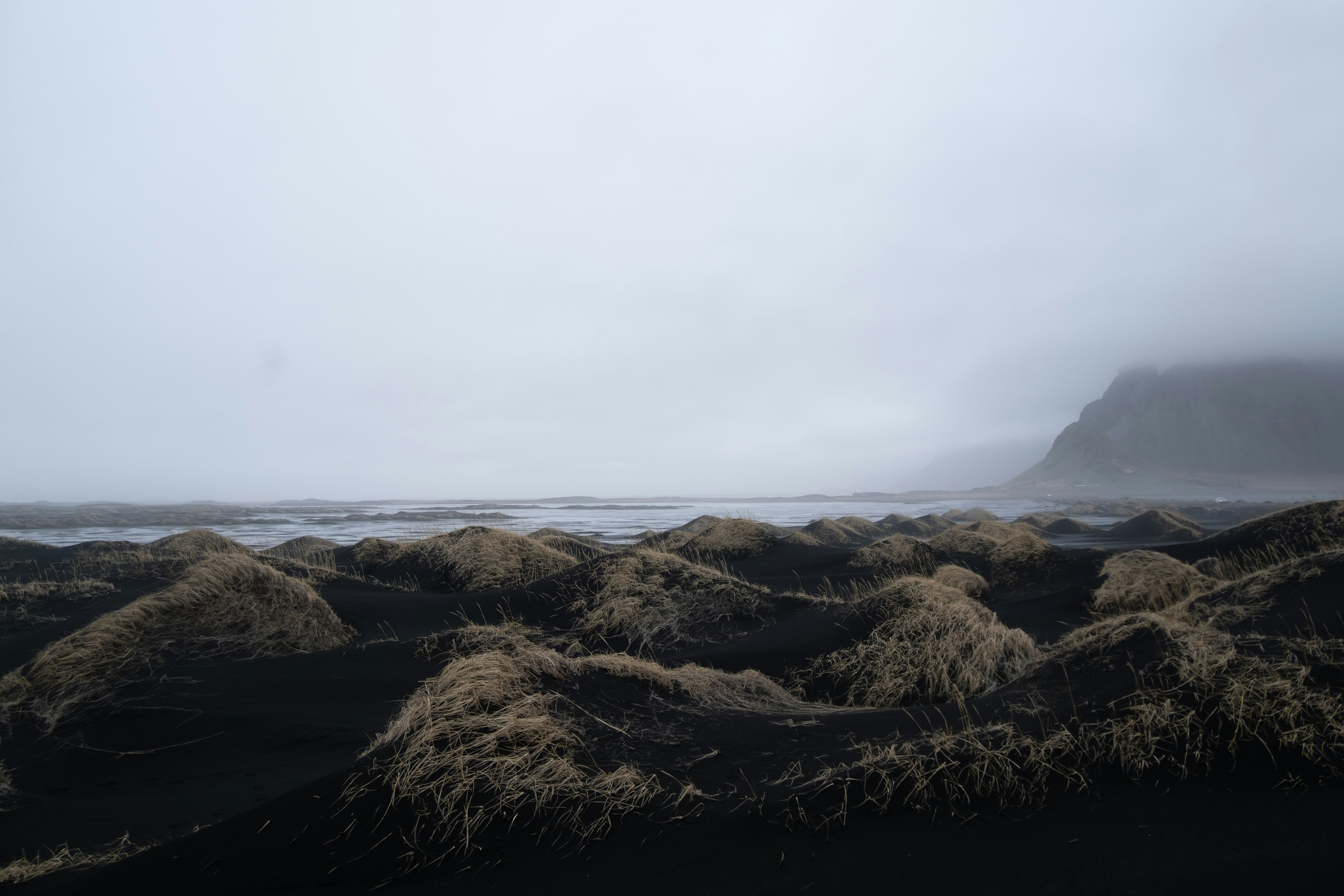 A beach covered in lots of sand next to the ocean photo – Free Iceland ...