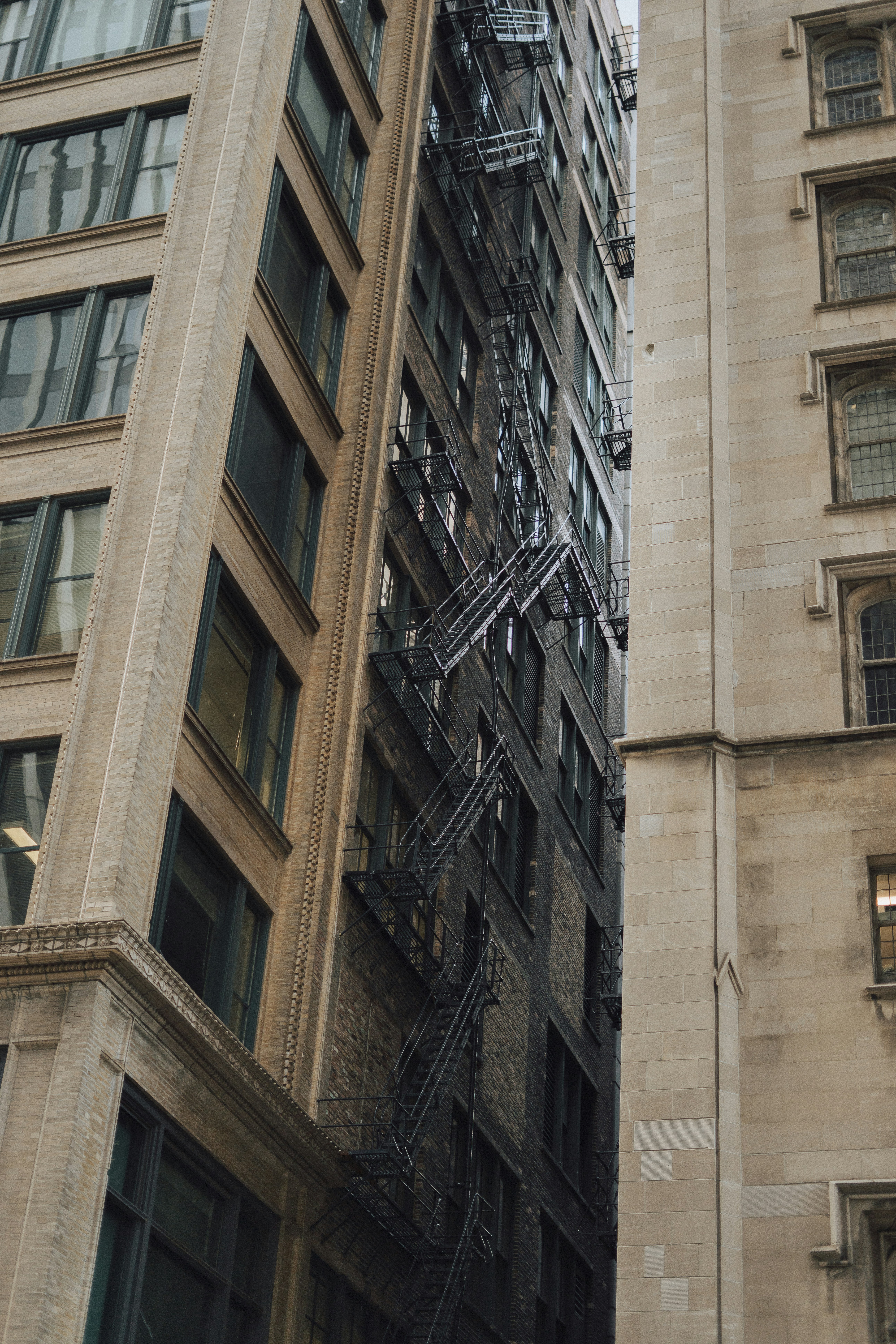 A tall building with a fire escape on the side of it photo – Free ...