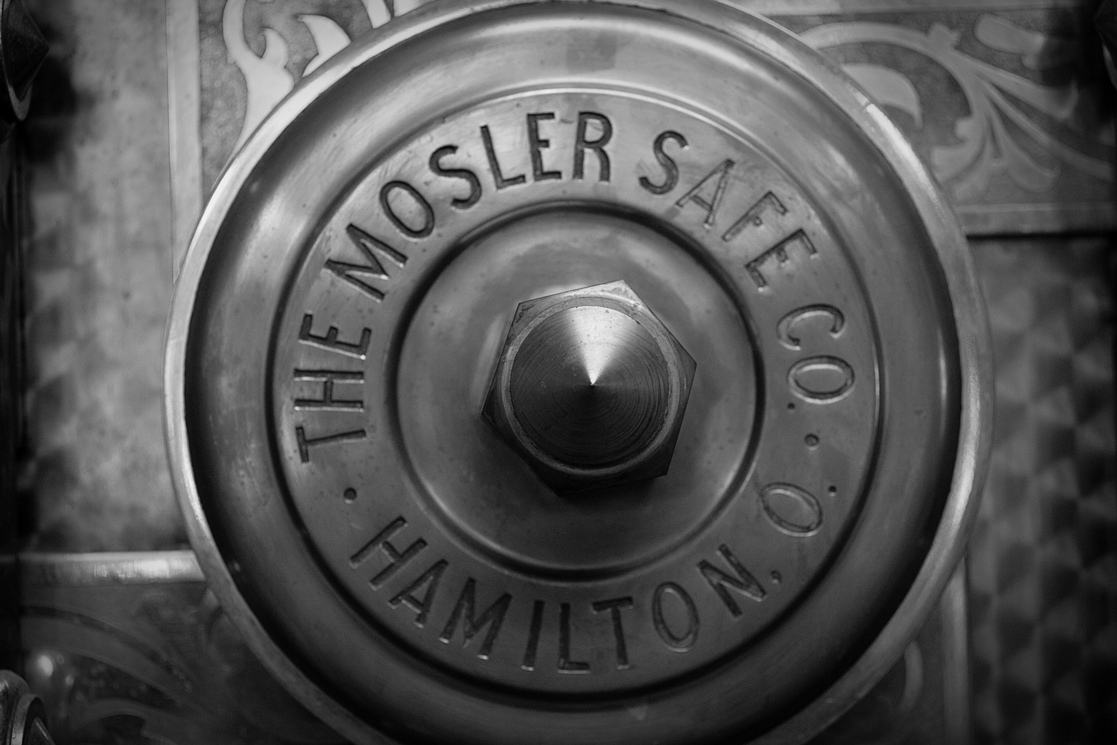 Close-up of an antique Mosler Safe Co. combination dial with intricate metal detailing.