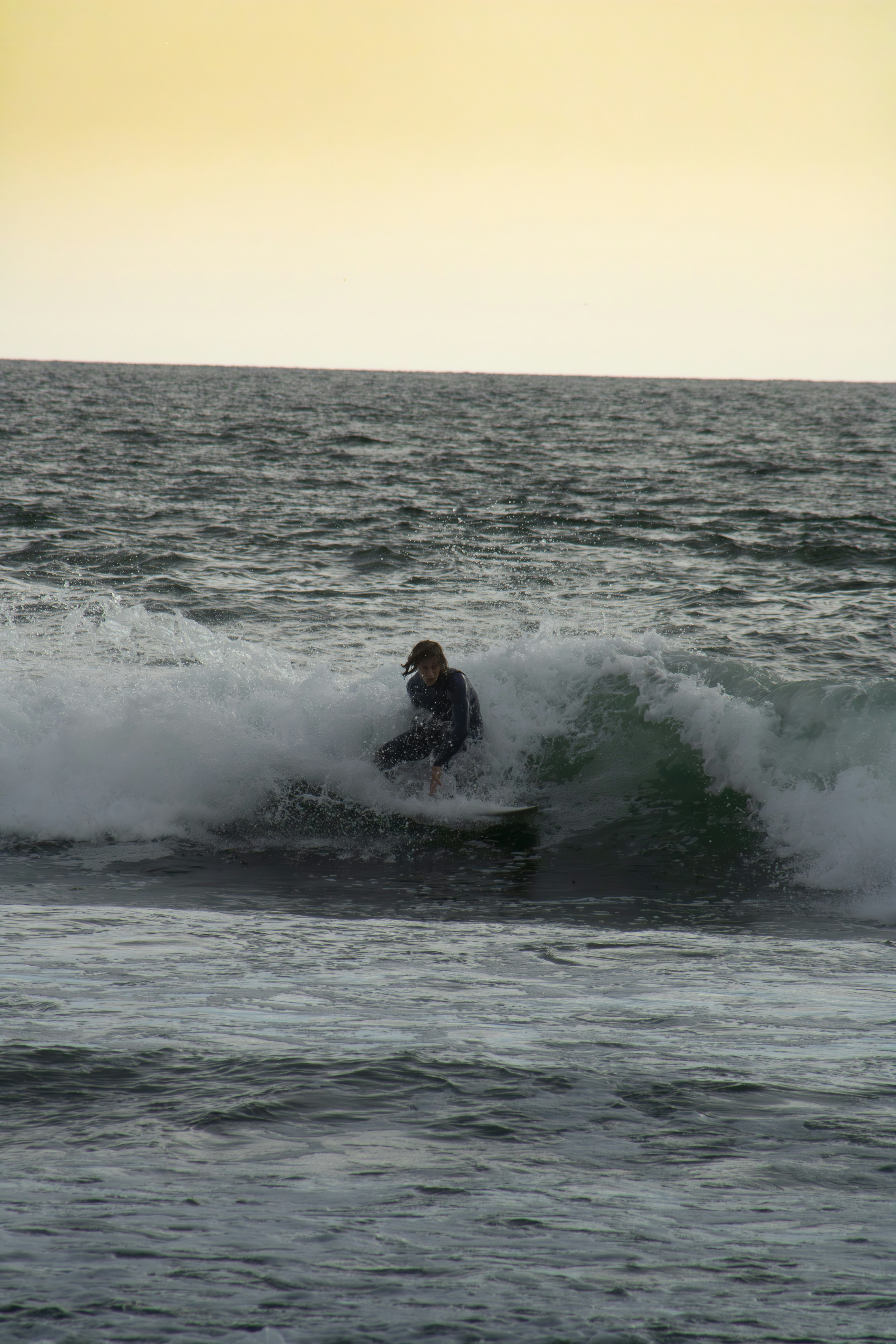 Dusk Crest: A Surfer Carves Through a Curl at Sunset