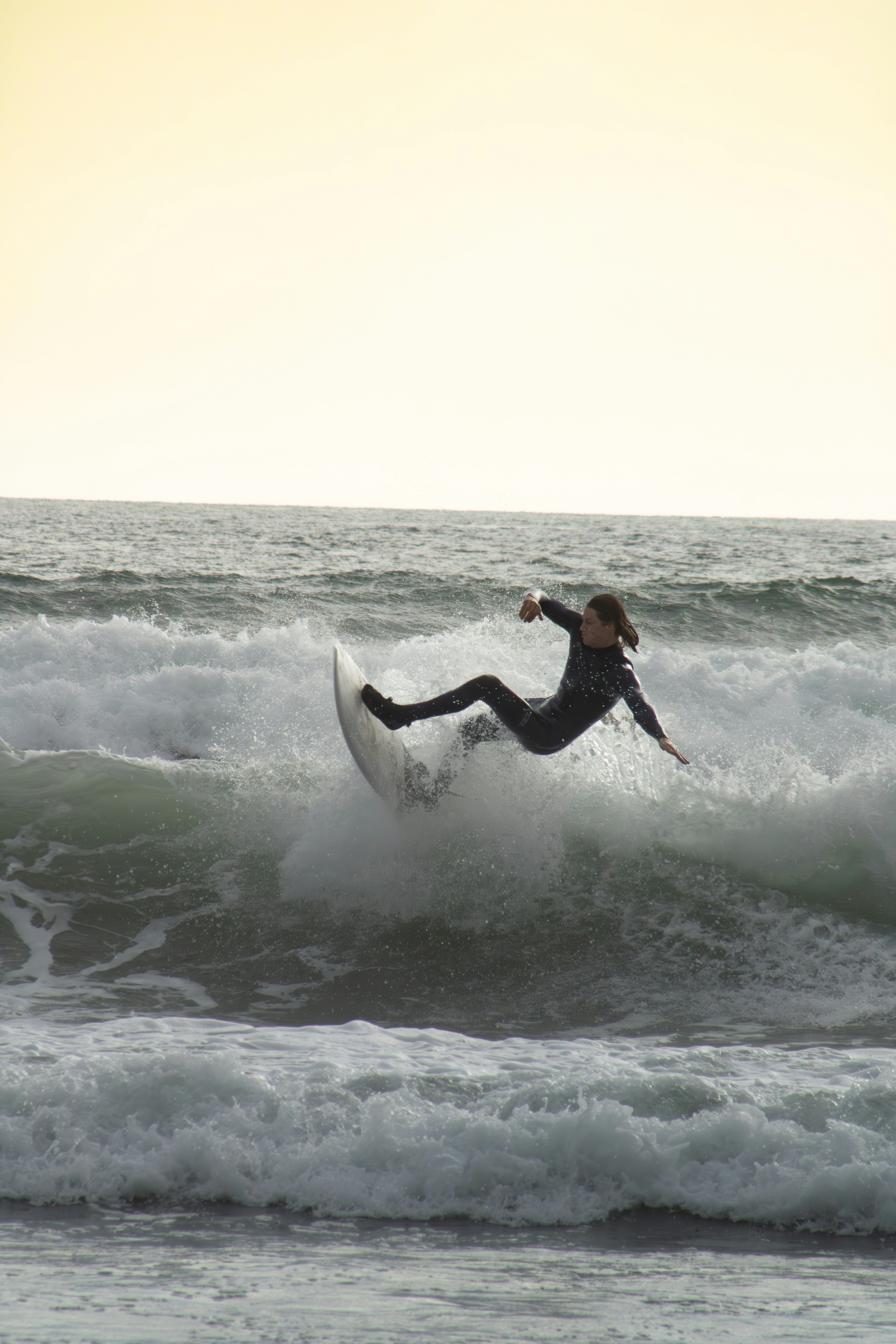 A person riding a surfboard on a wave in the ocean photo – Free Woman ...