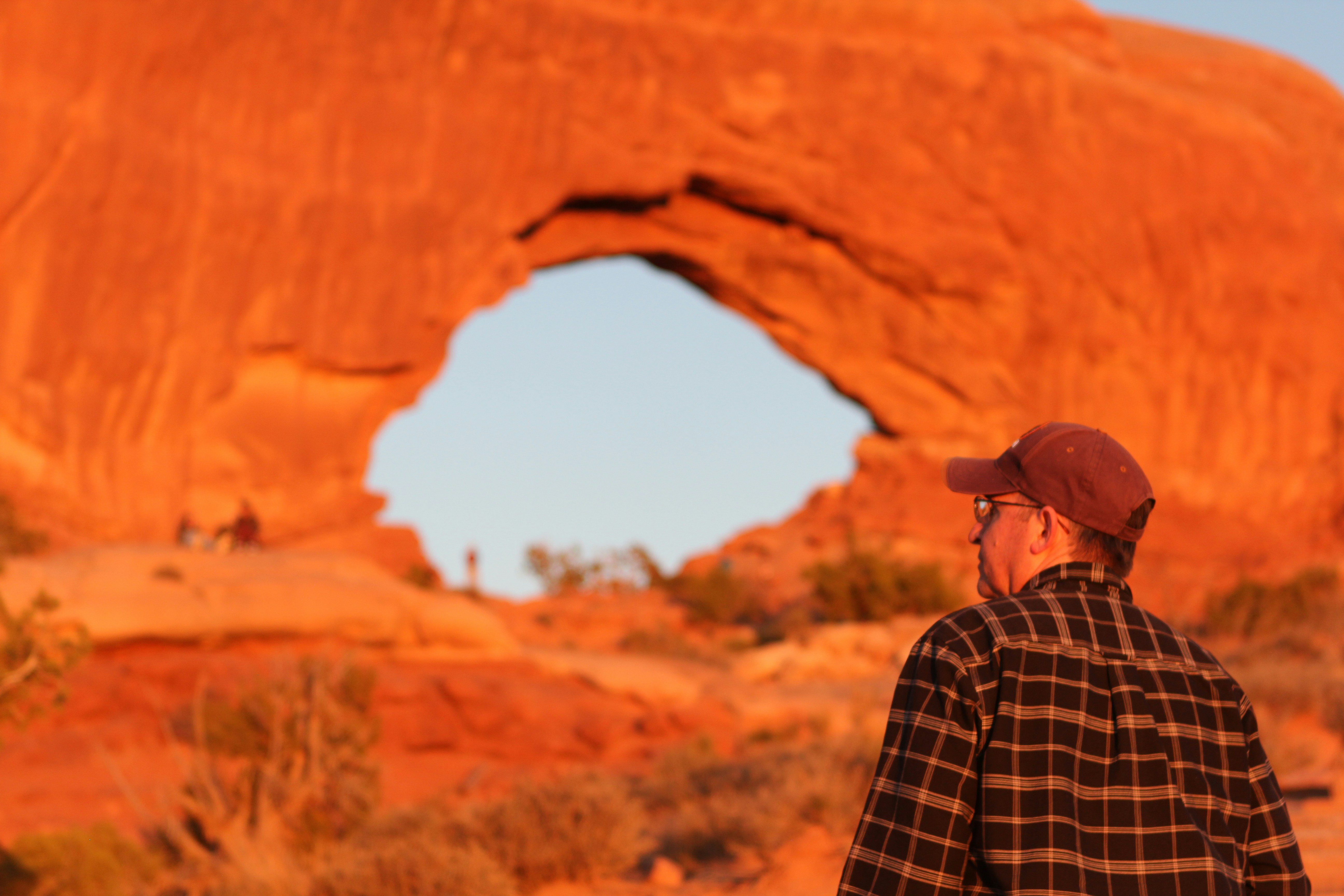 Ember Archway: A Solo Explorer in a Sunlit Red Rock Landscape