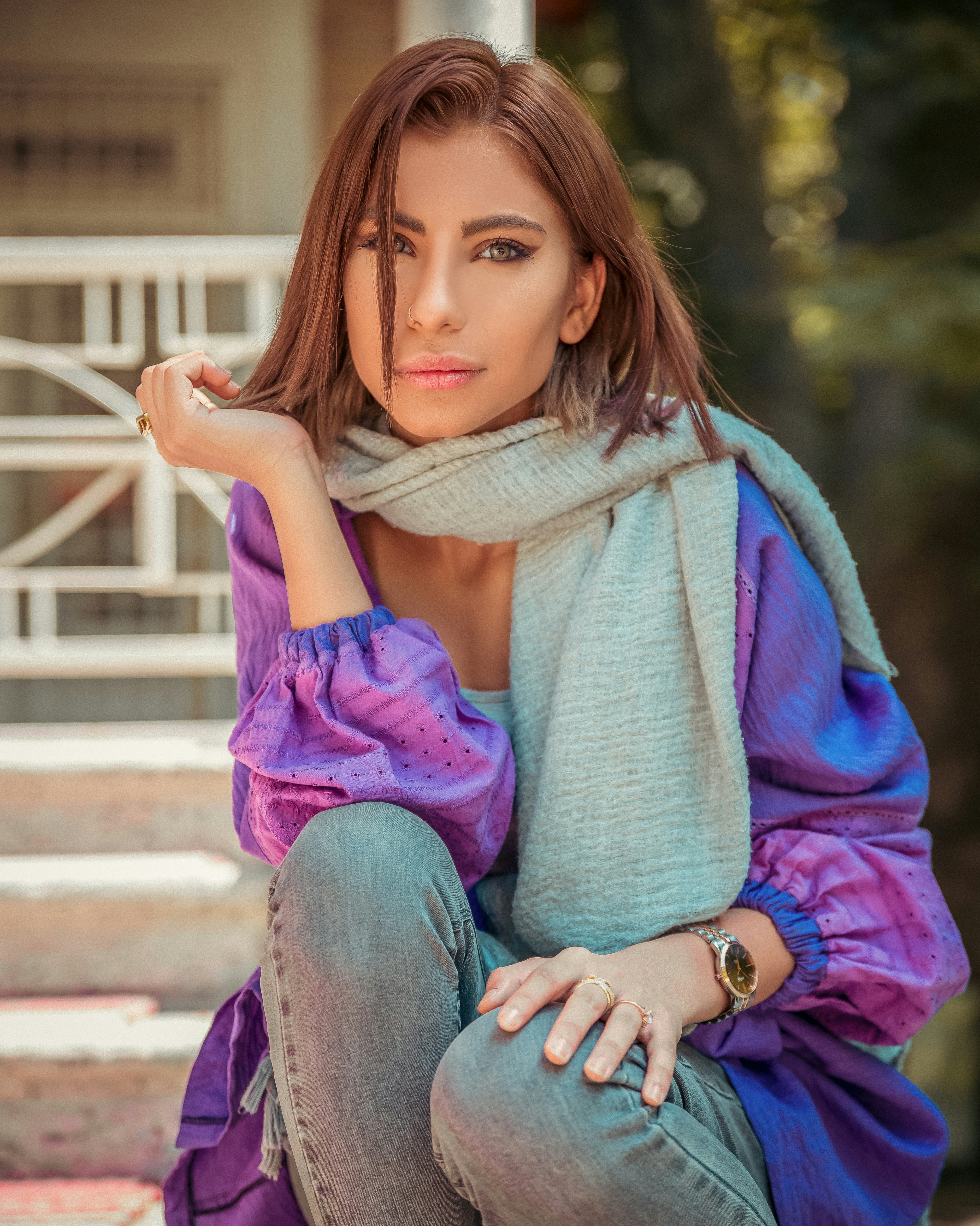 A woman sitting on steps with a scarf around her neck photo – Free Girl ...