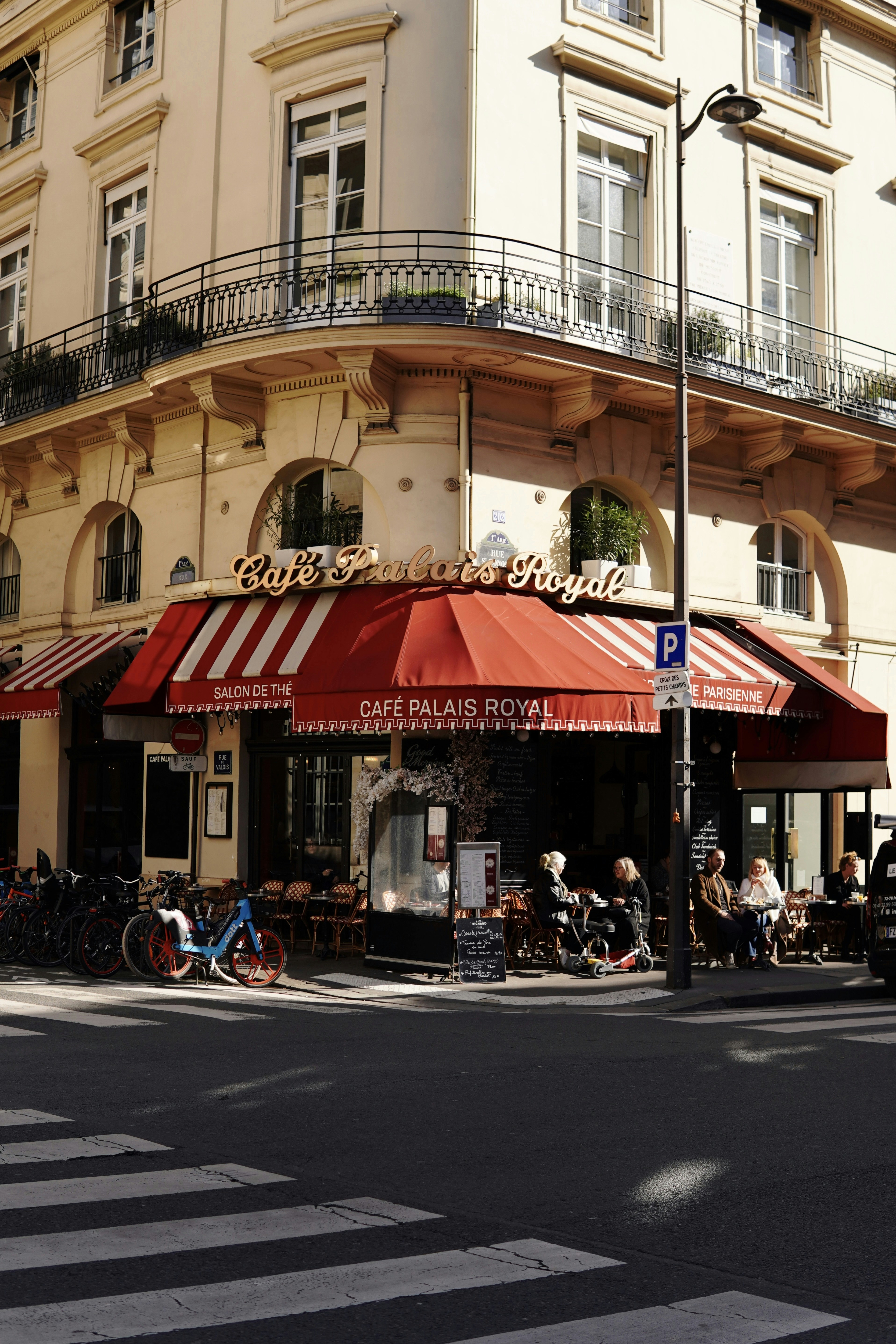 Scarlet Stripes Over a Parisian Café on a Sunlit Corner