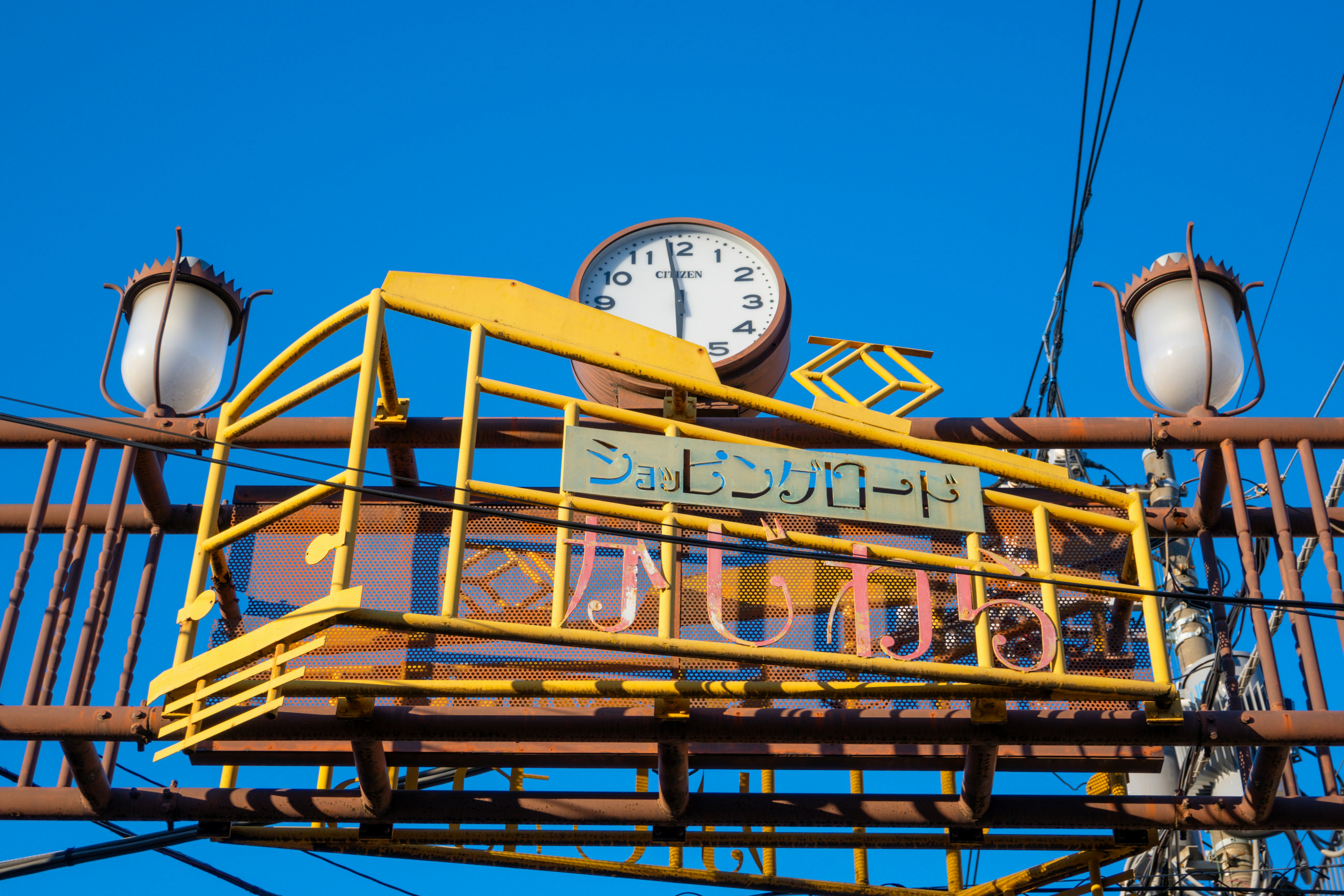 Noon Clock Over a Neon-Yellow Gateway Against a Clear Azure