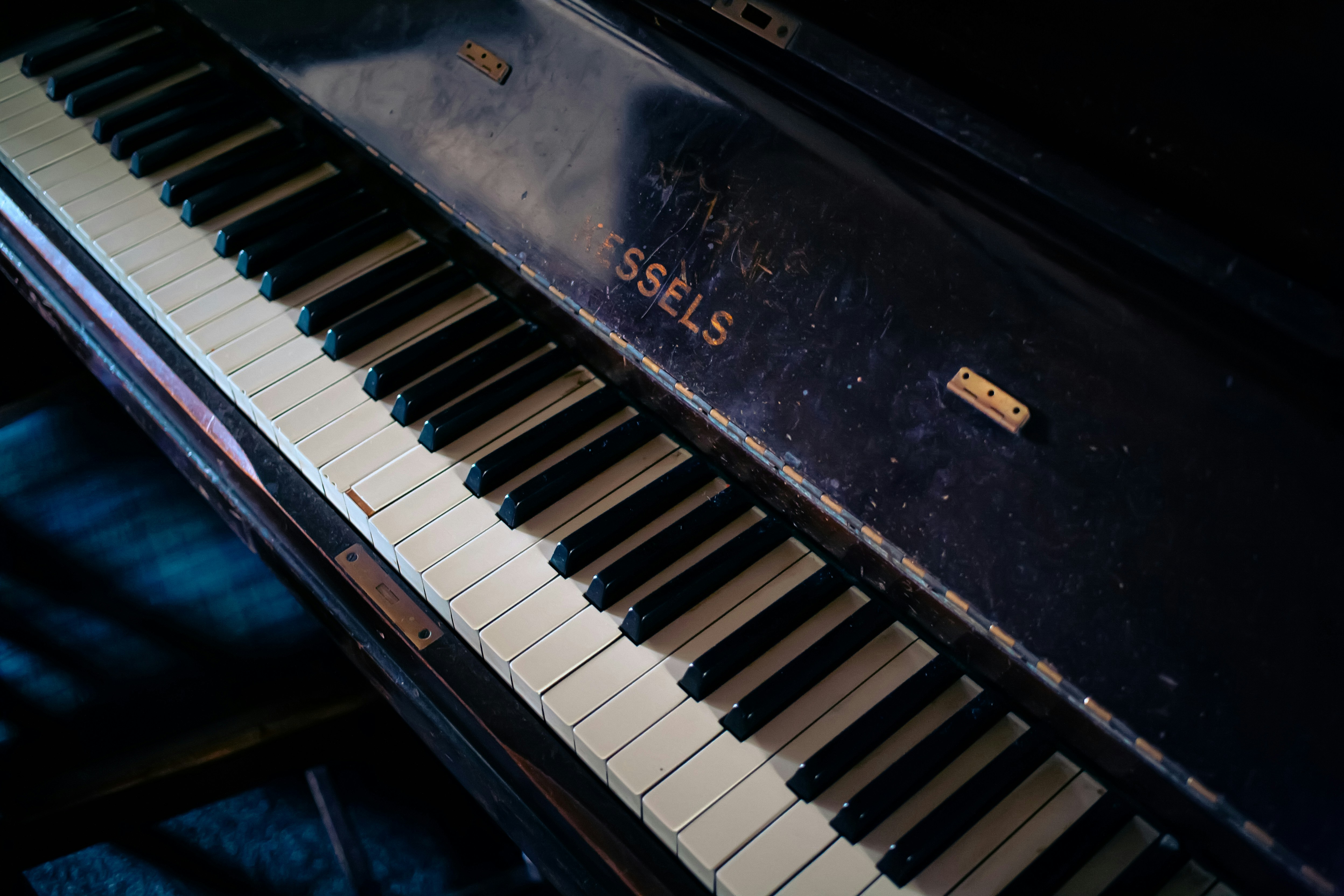 Aged Ebony and Ivory in Dim Light: Close-Up on a Weathered Grand