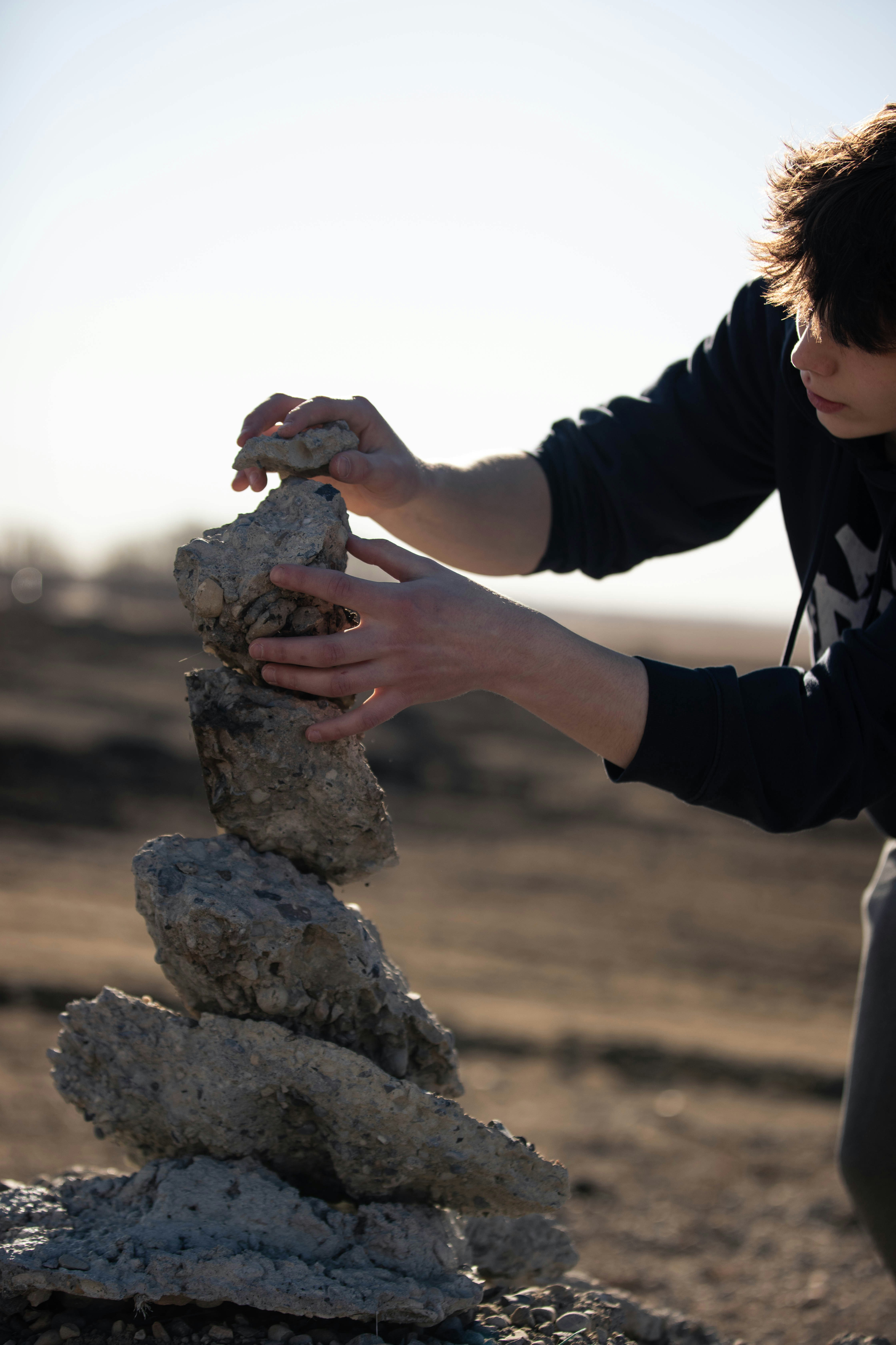 A person stacking rocks on top of each other photo – Free Beach Image ...