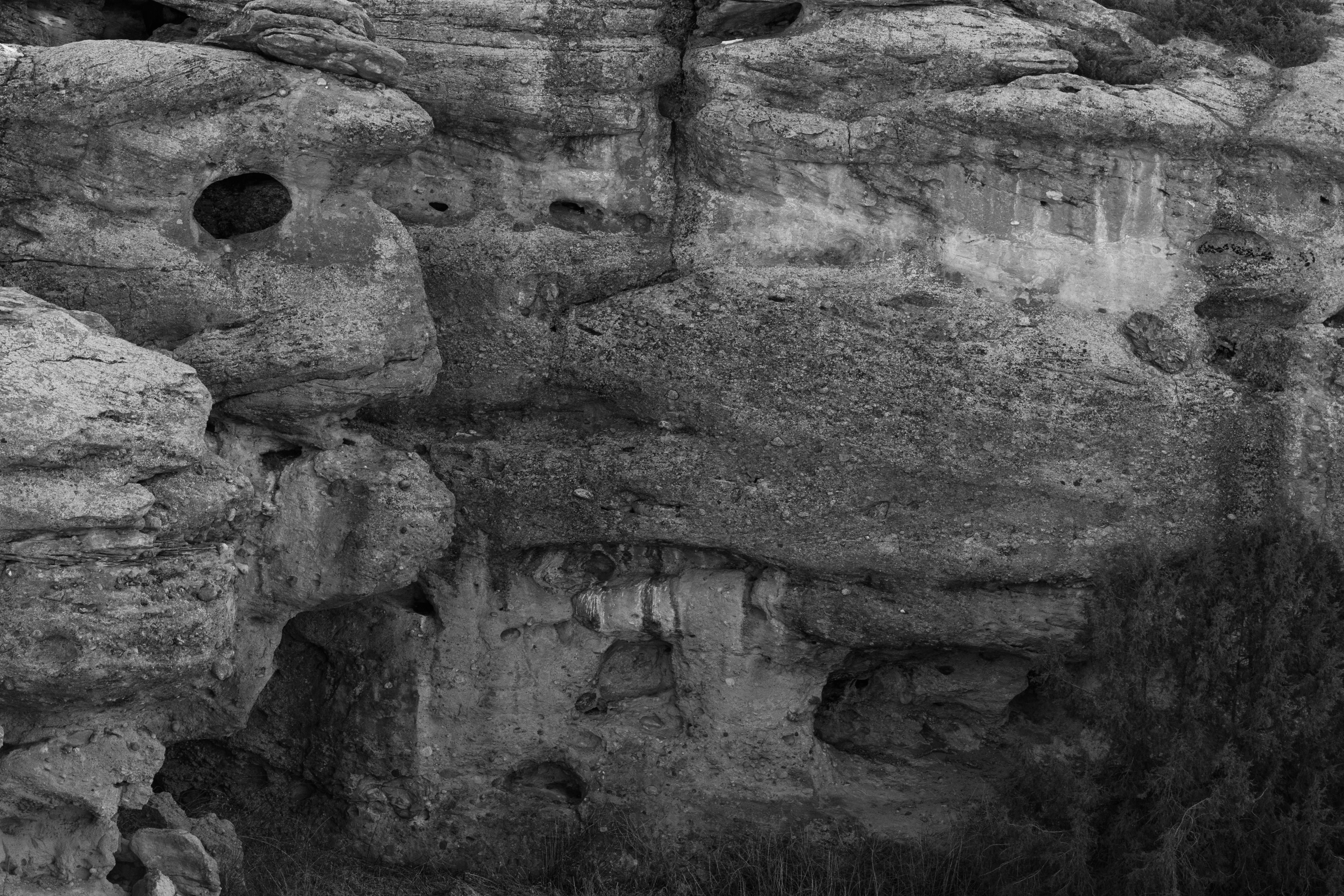 Rock formations with distinct erosion patterns and cavities under soft lighting.