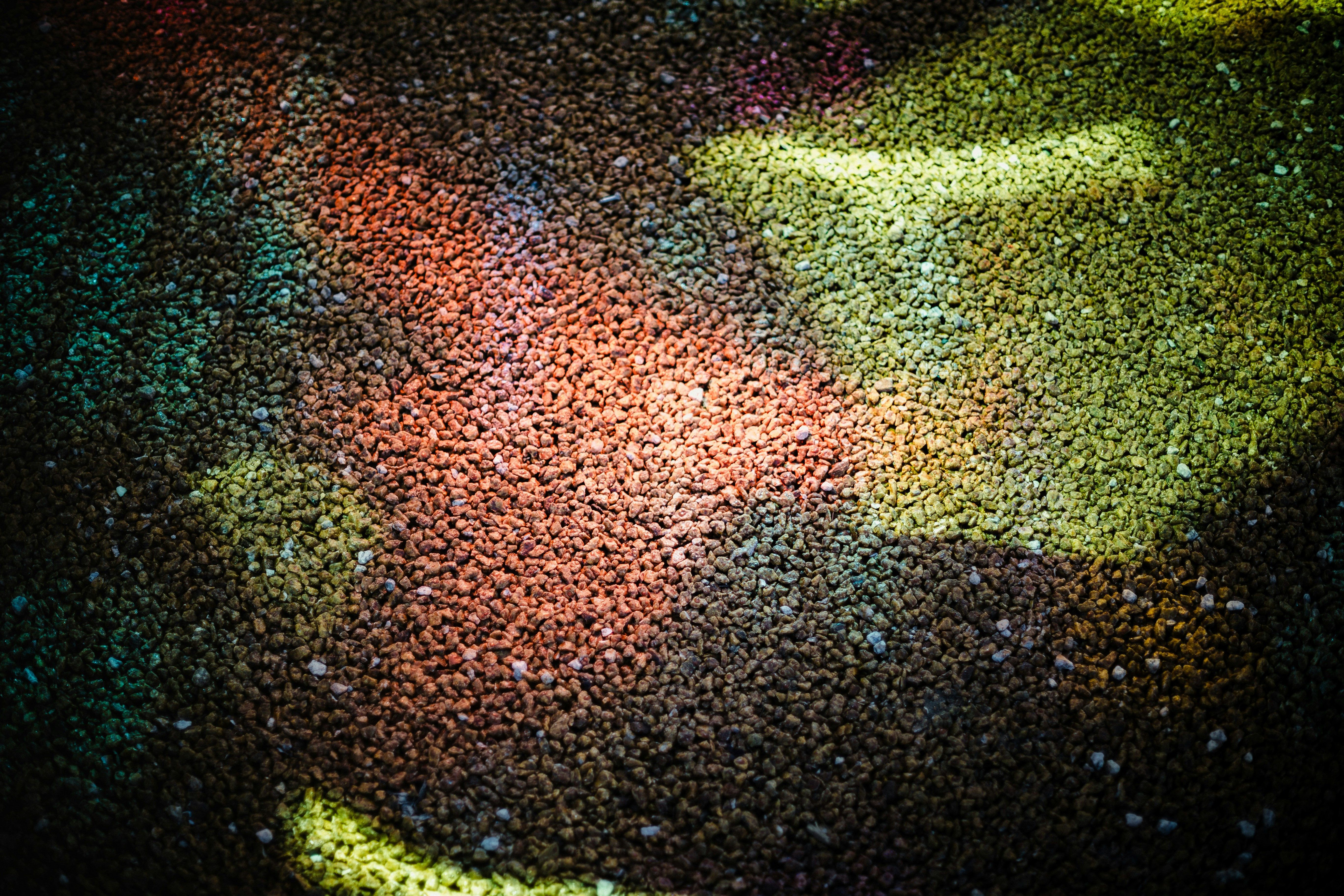 Chromatic Pebble Mosaic: Neon Reflections on a Gravel Surface
