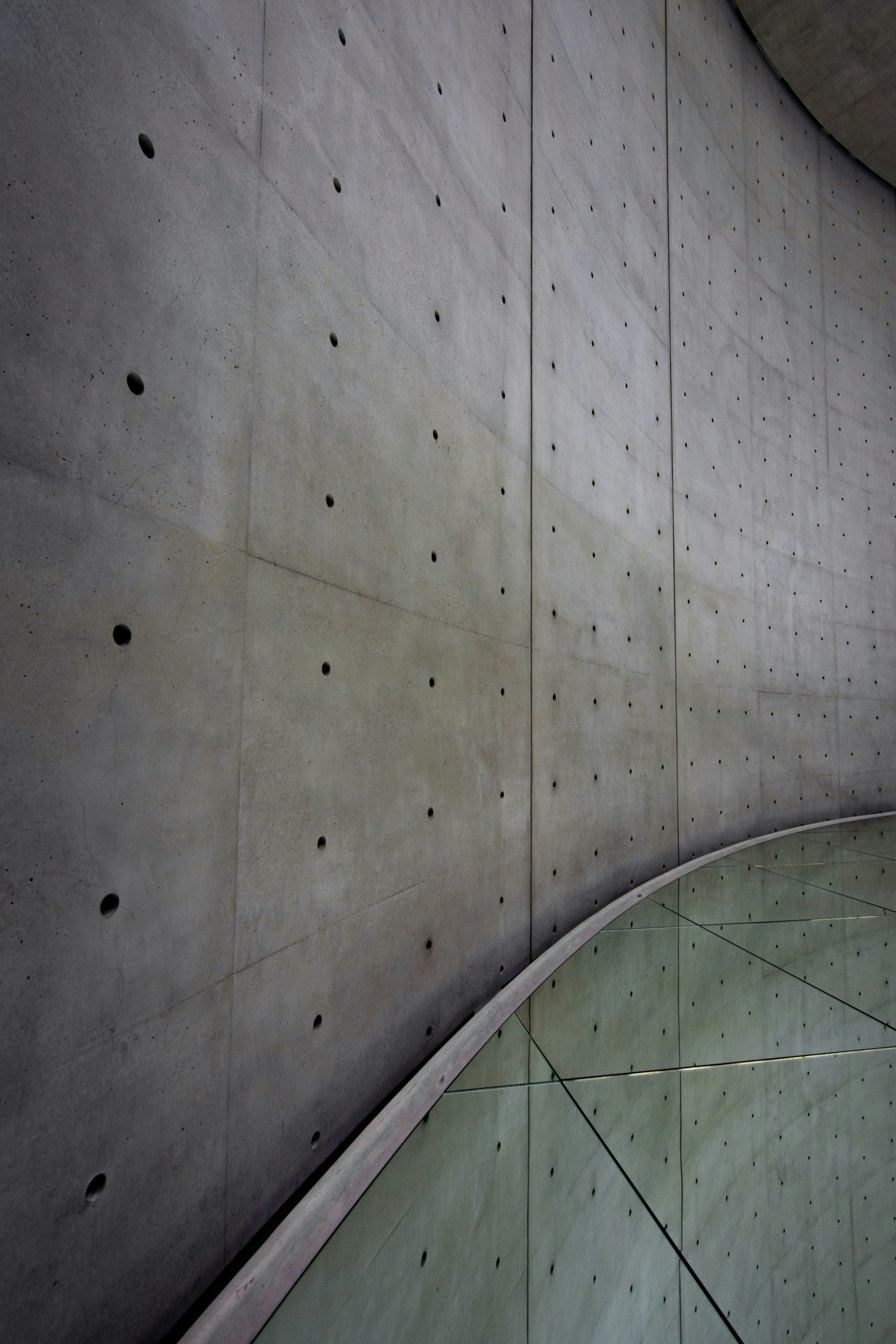 A curved concrete wall with holes in it photo – Free France Image on ...