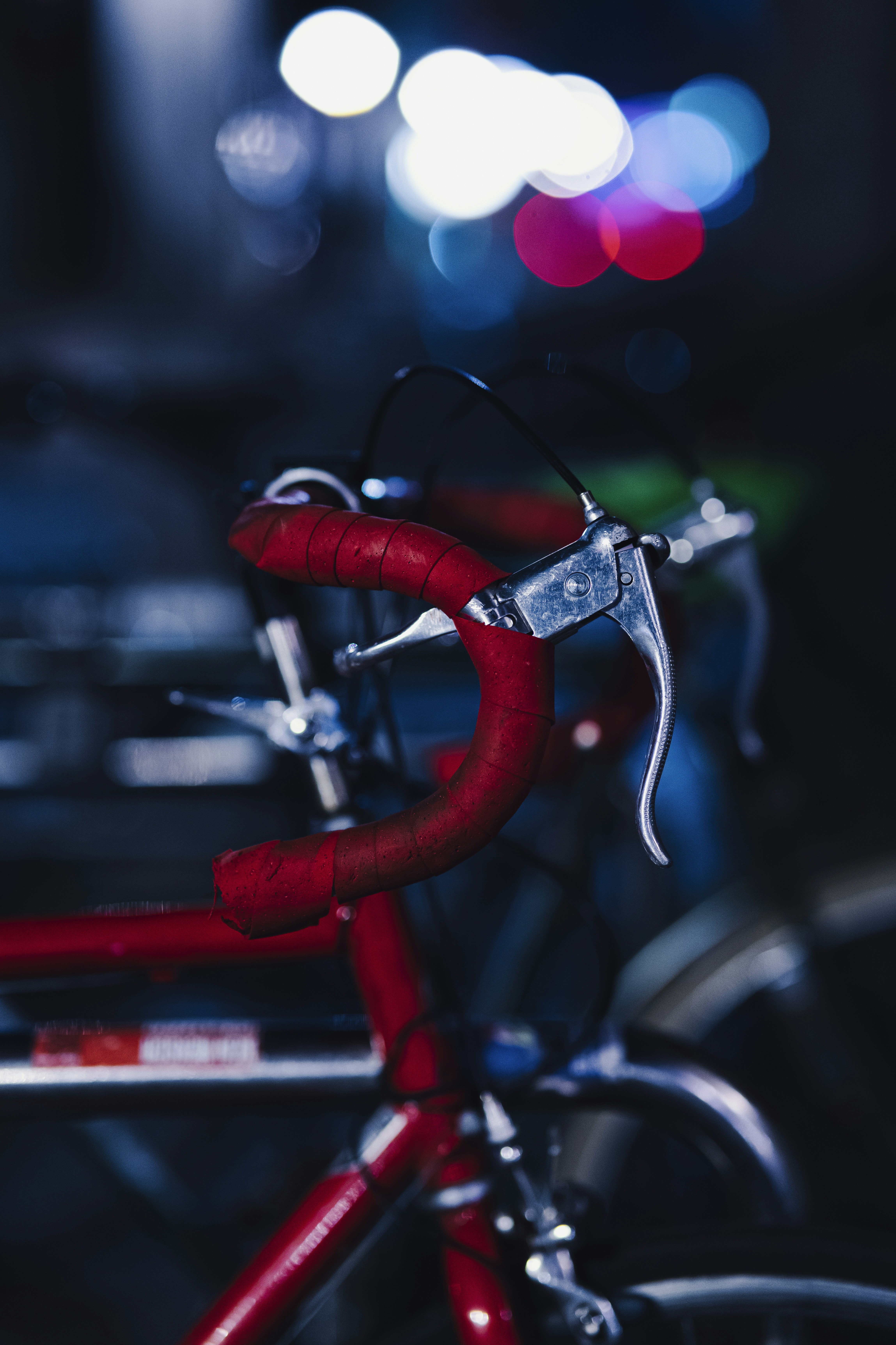Crimson Handlebar: A Nighttime Close-Up of a Racing Bike Cockpit