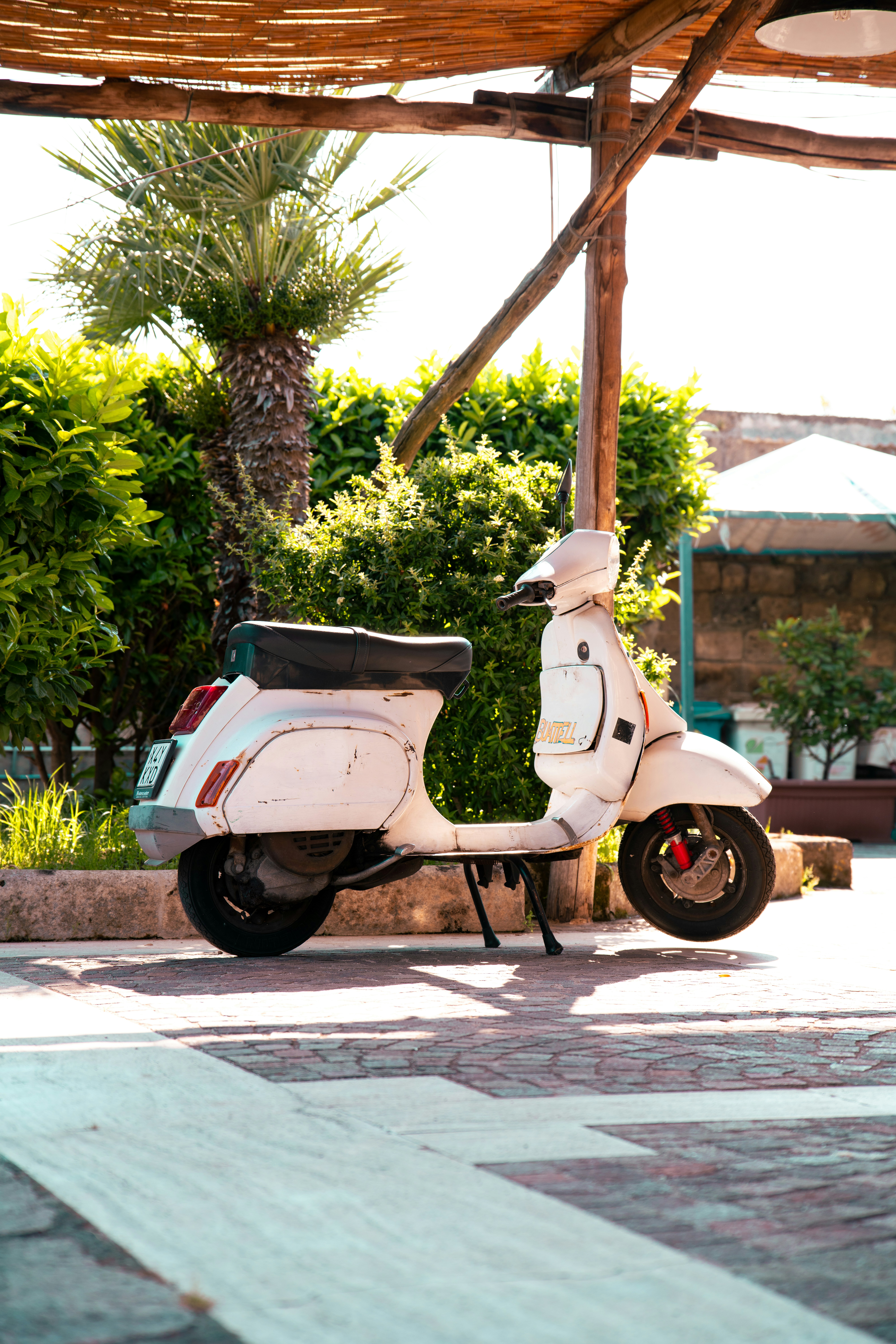 Sunlit Vespa Retreat under a Rustic Pergola