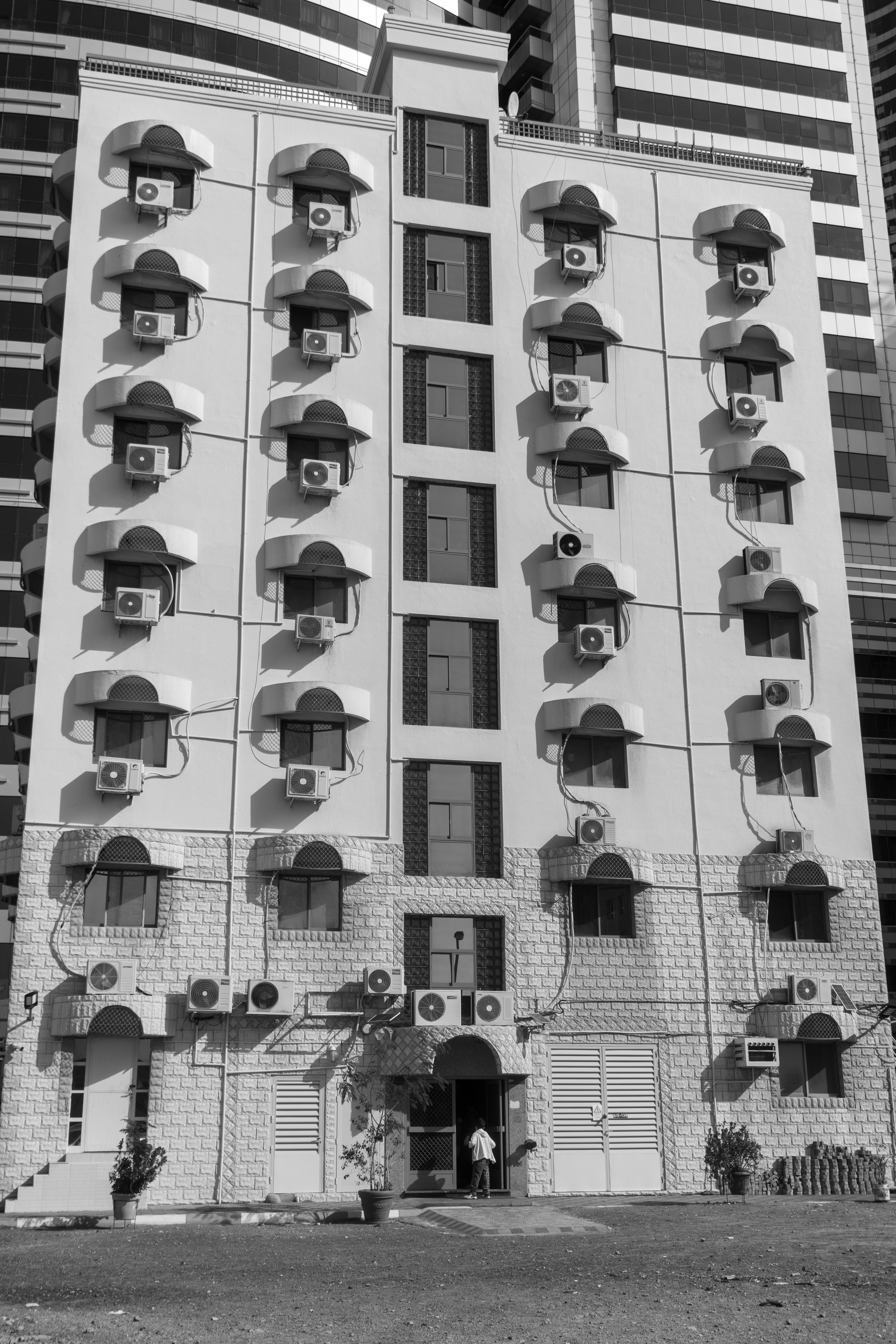 Facade of a Graceful Grid: Rows of Windowed Air Conditioning Units on a Modern Jumble
