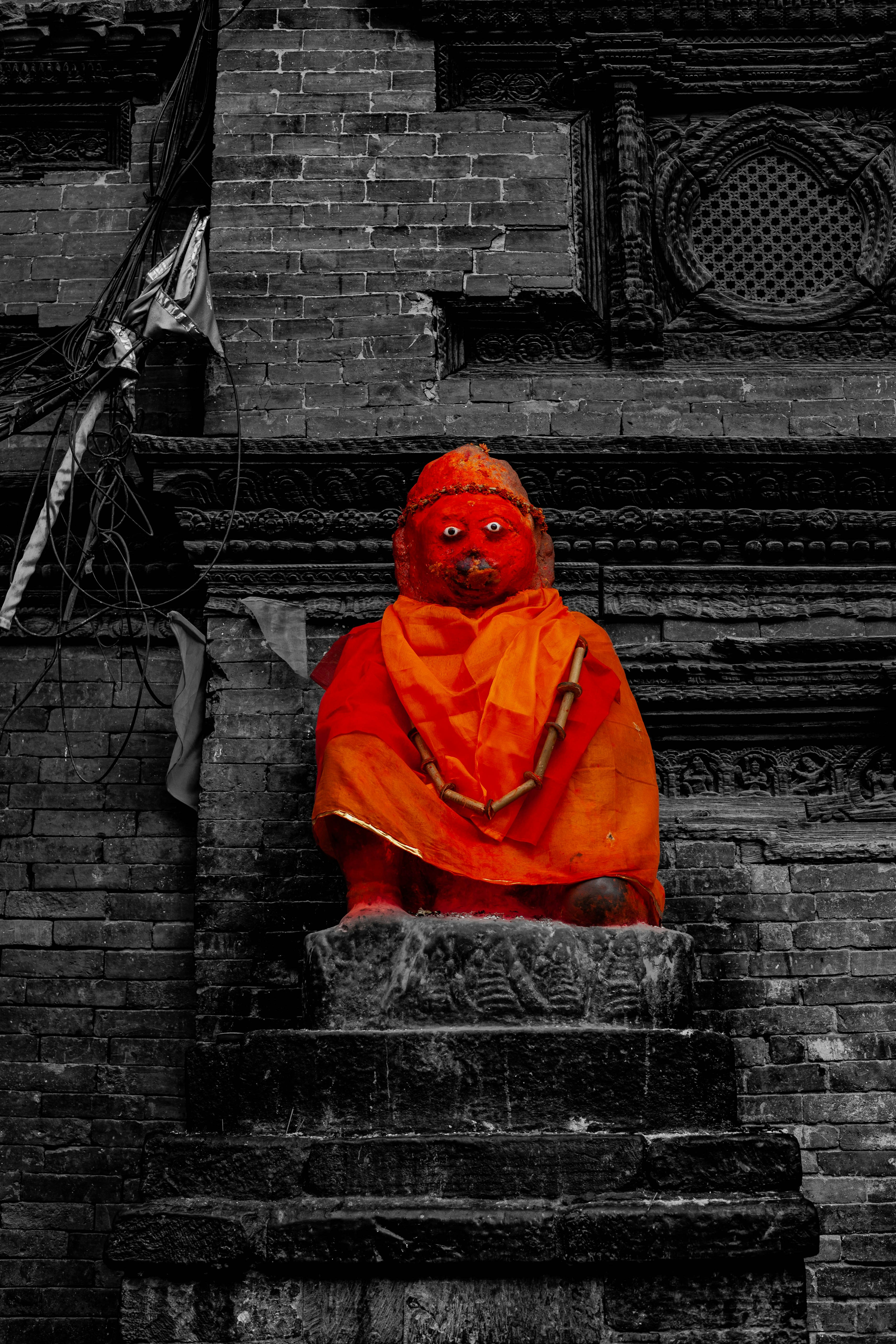 Crimson Guardian on Stone Steps: A solitary idol amid shadowed temple walls