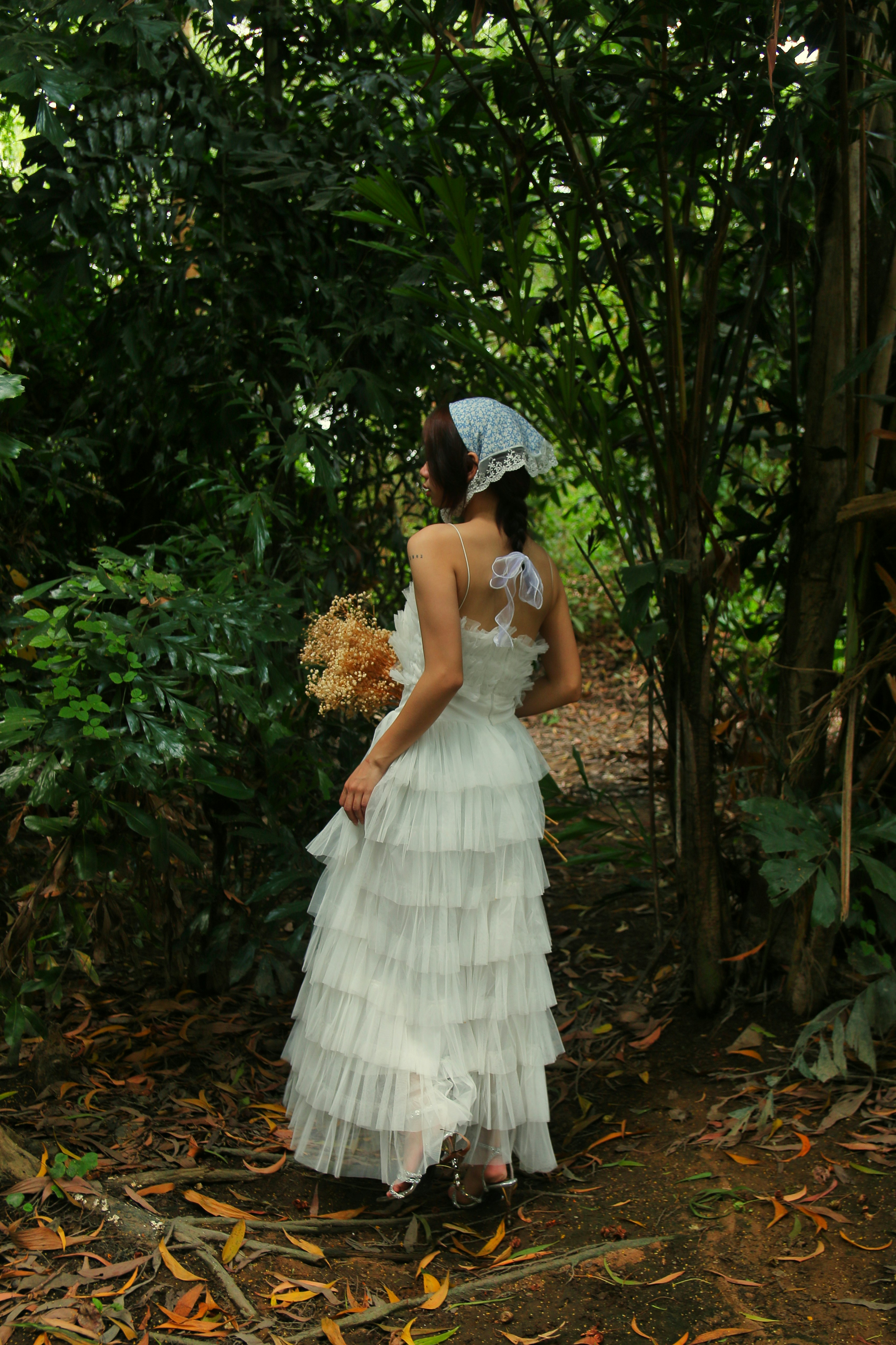 Tiered Lace in a Green Corridor: A Back-View Bridal Portrait