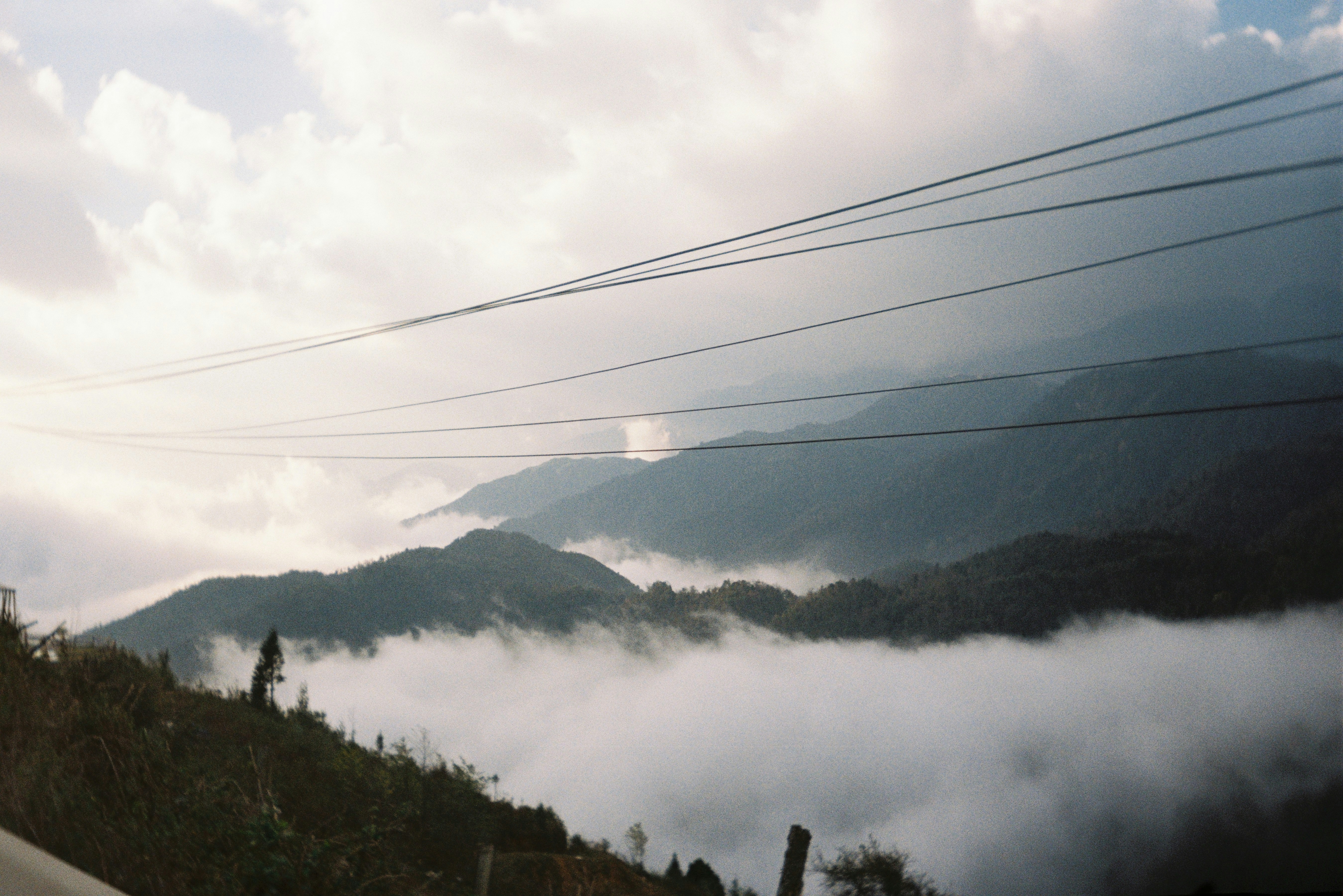 Mist Over the Ridge as Power Lines Trace a Quiet Mountain Morning