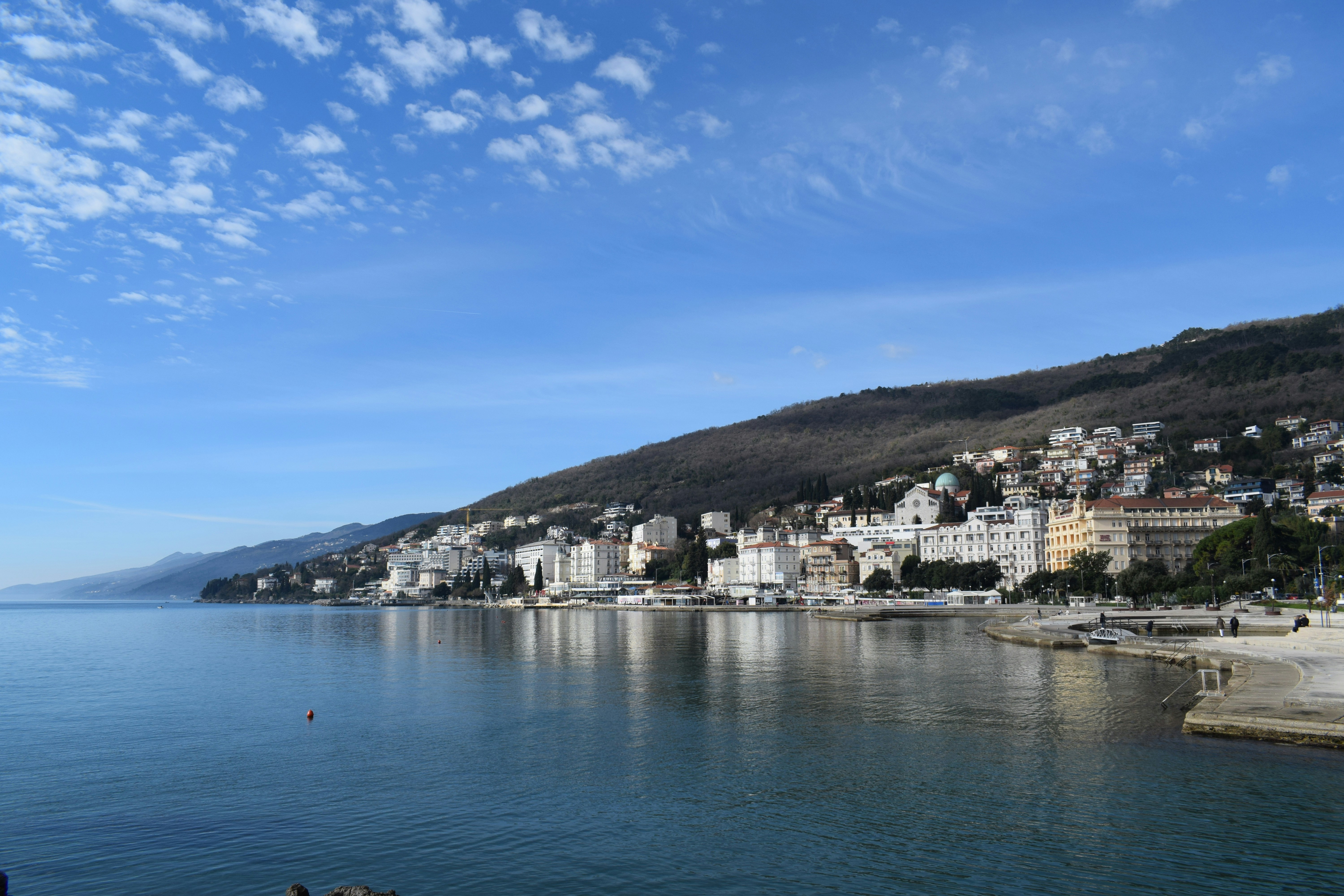 Harborfront Mosaic: A White-Washed Town Framed by a Glassy Bay