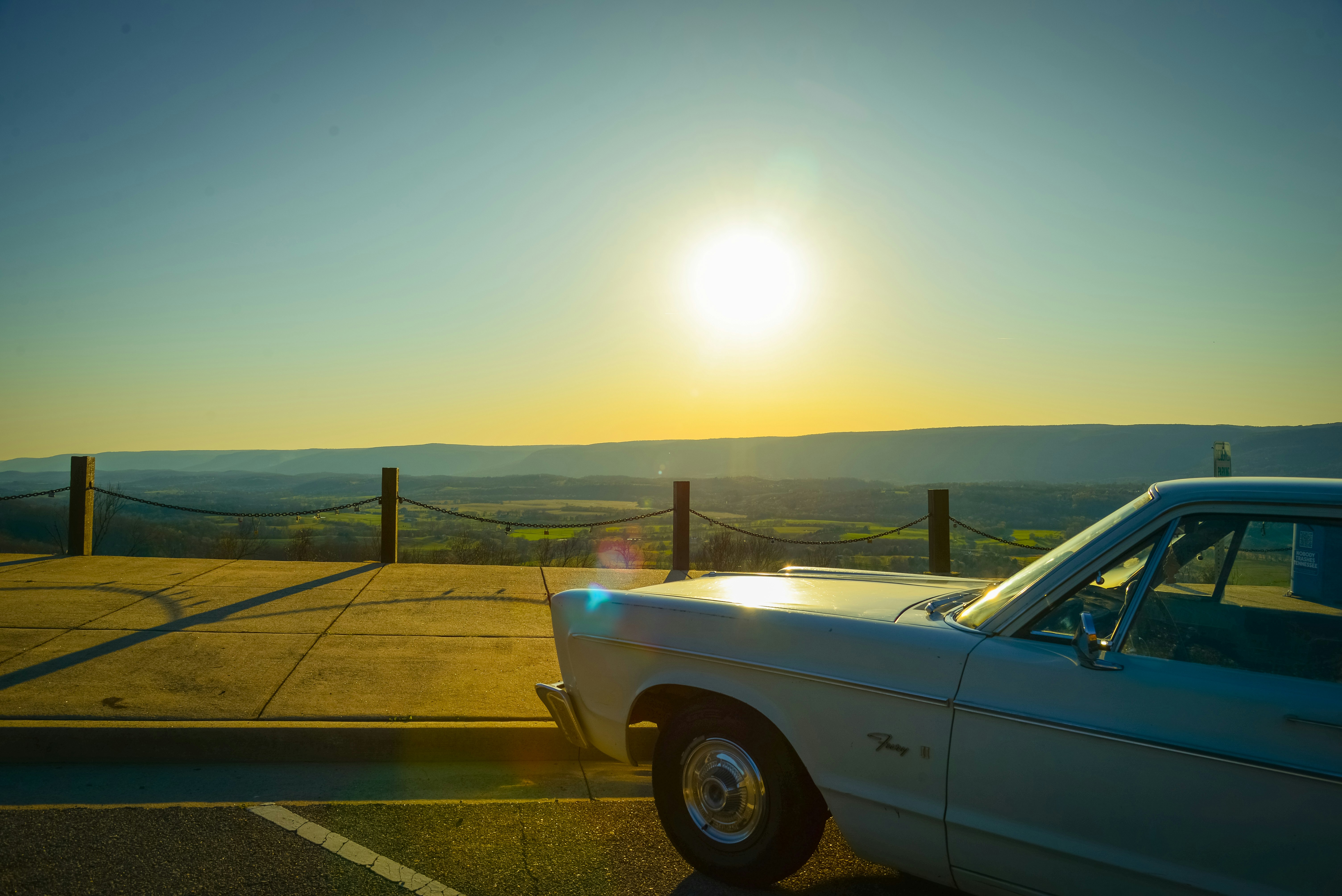 Sunlit Horizon and Classic Car at a Bell-Bottom Sunset