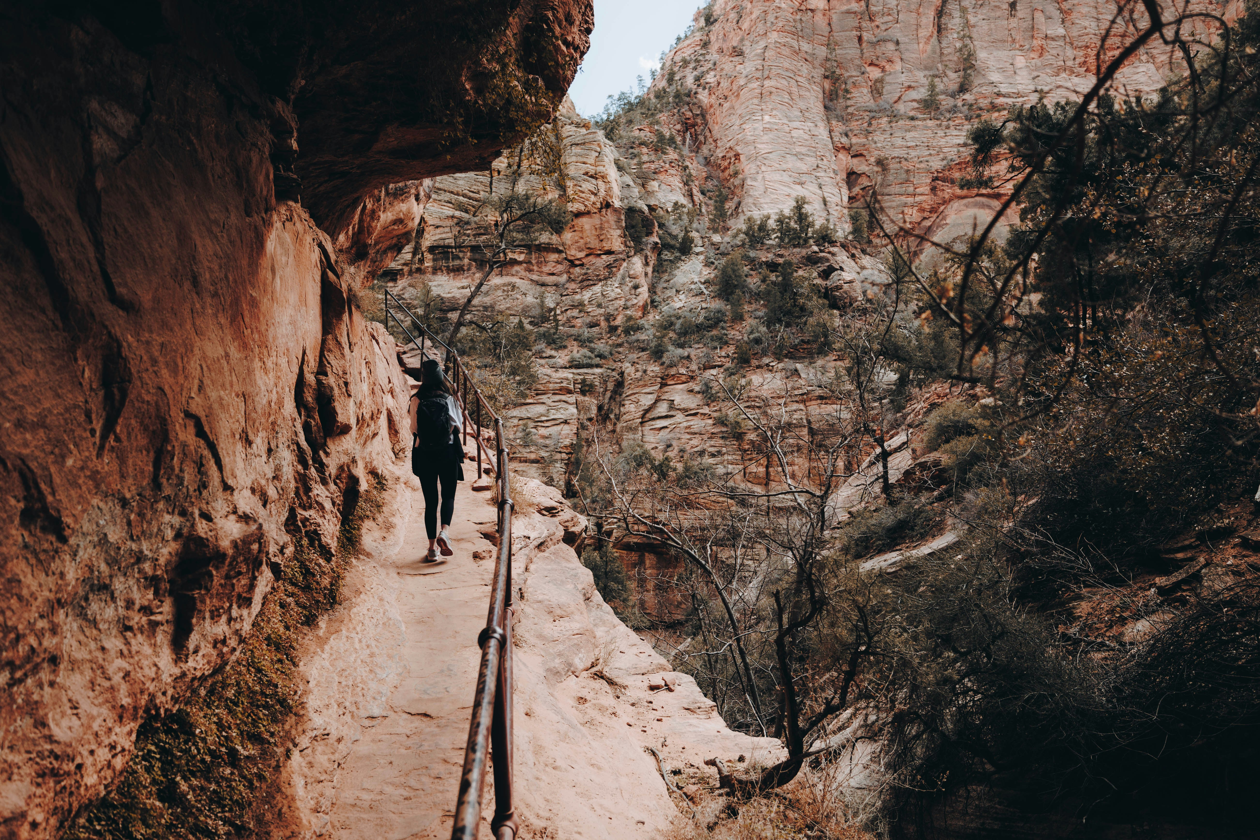 A person walking up a narrow path in a canyon photo – Free Human Image ...