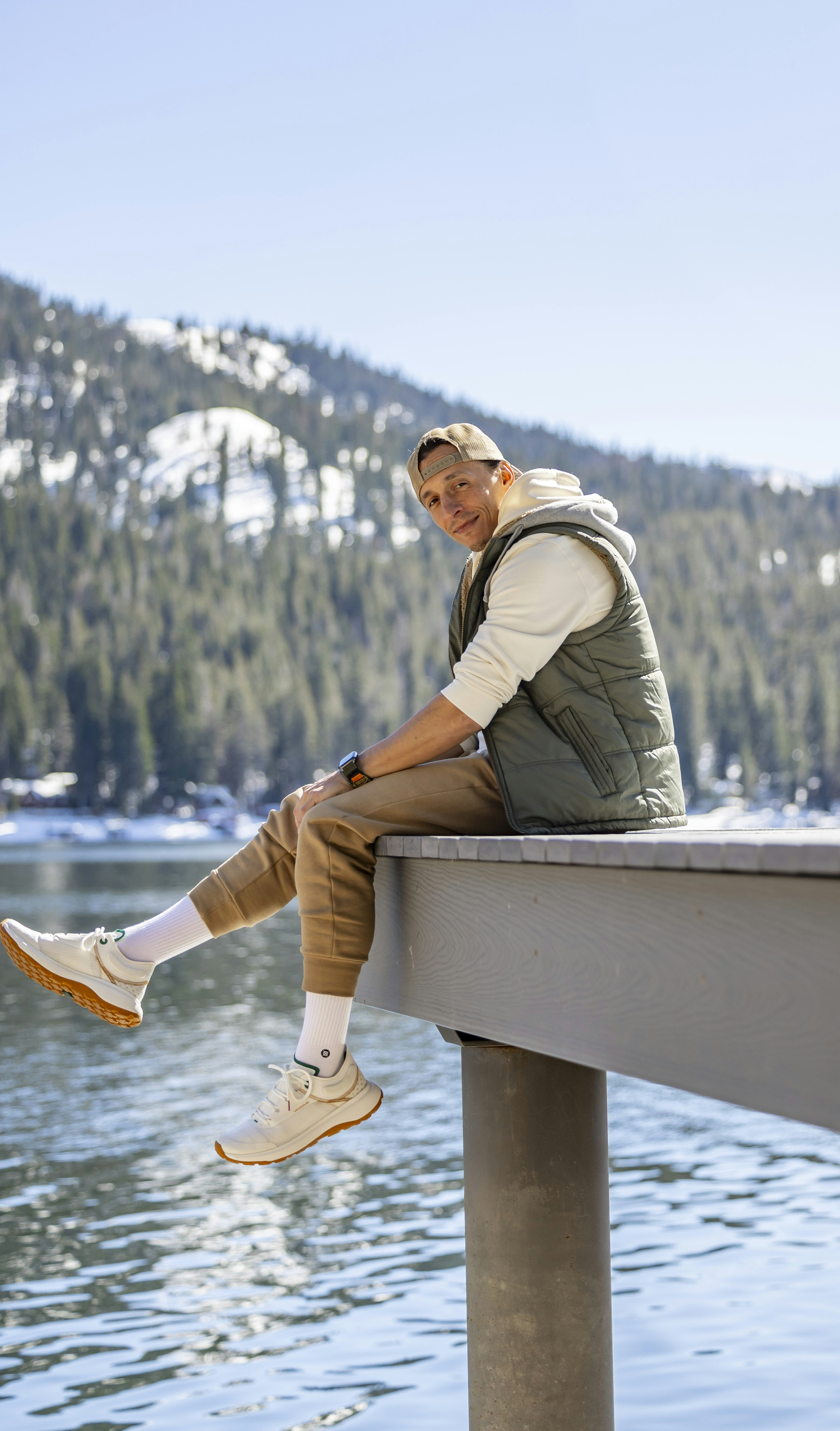 Lakeside Confidence: A Casual Portrait by Snow-Dusted Peaks