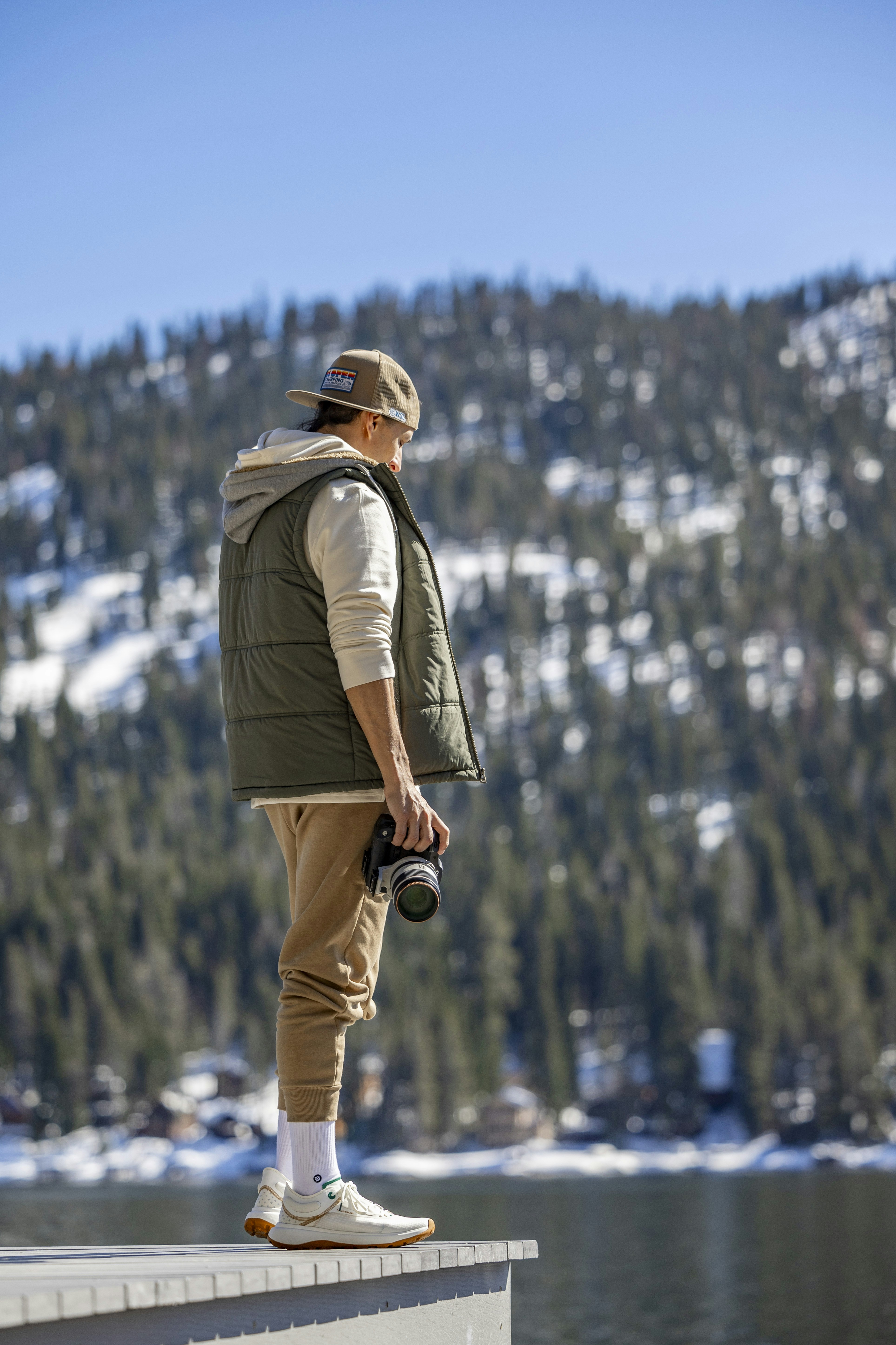 A man standing on a ledge with a camera photo – Free Summer Image on ...