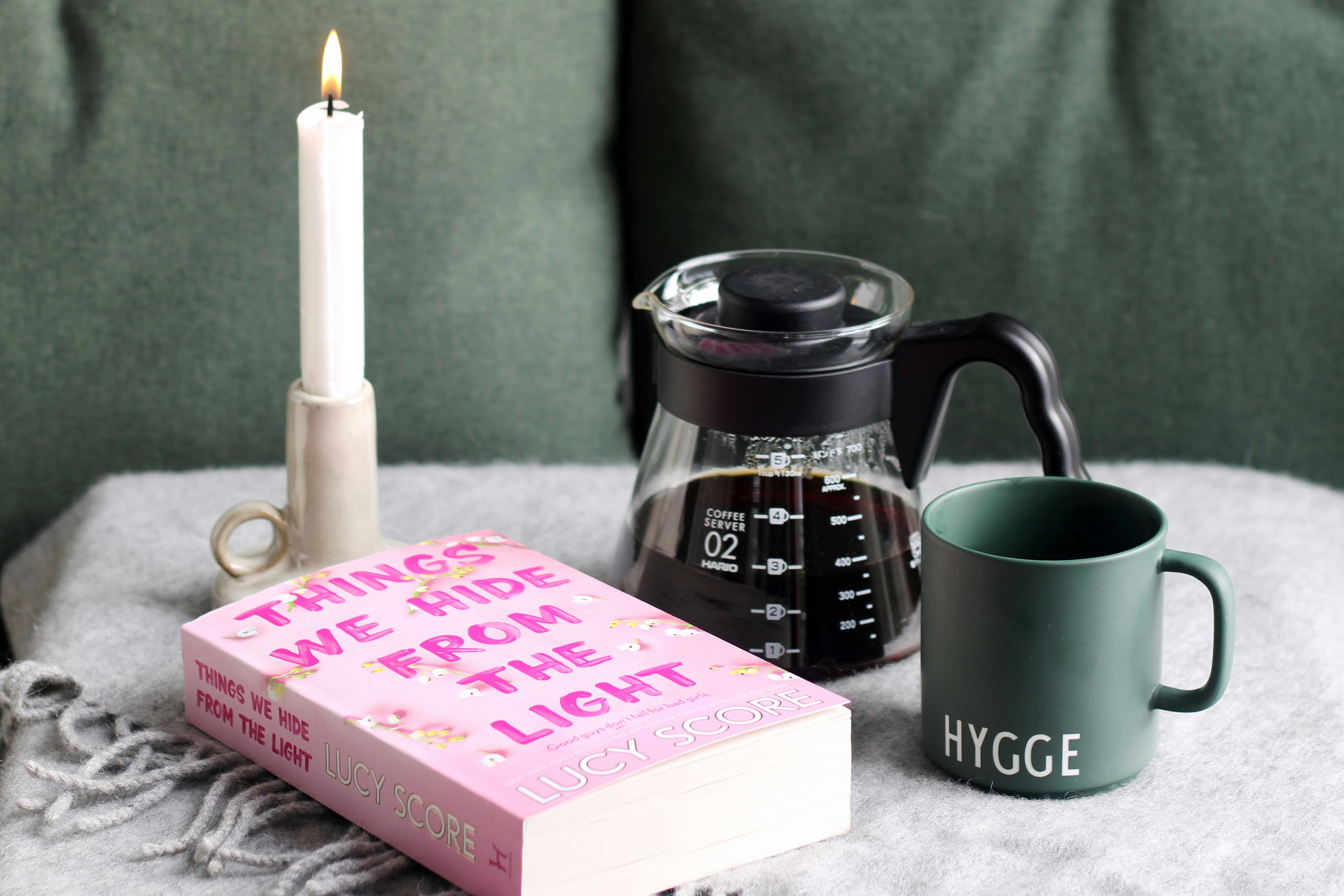 Candlelight and Pink Pages: A Hygge Still Life with Carafe and Cup