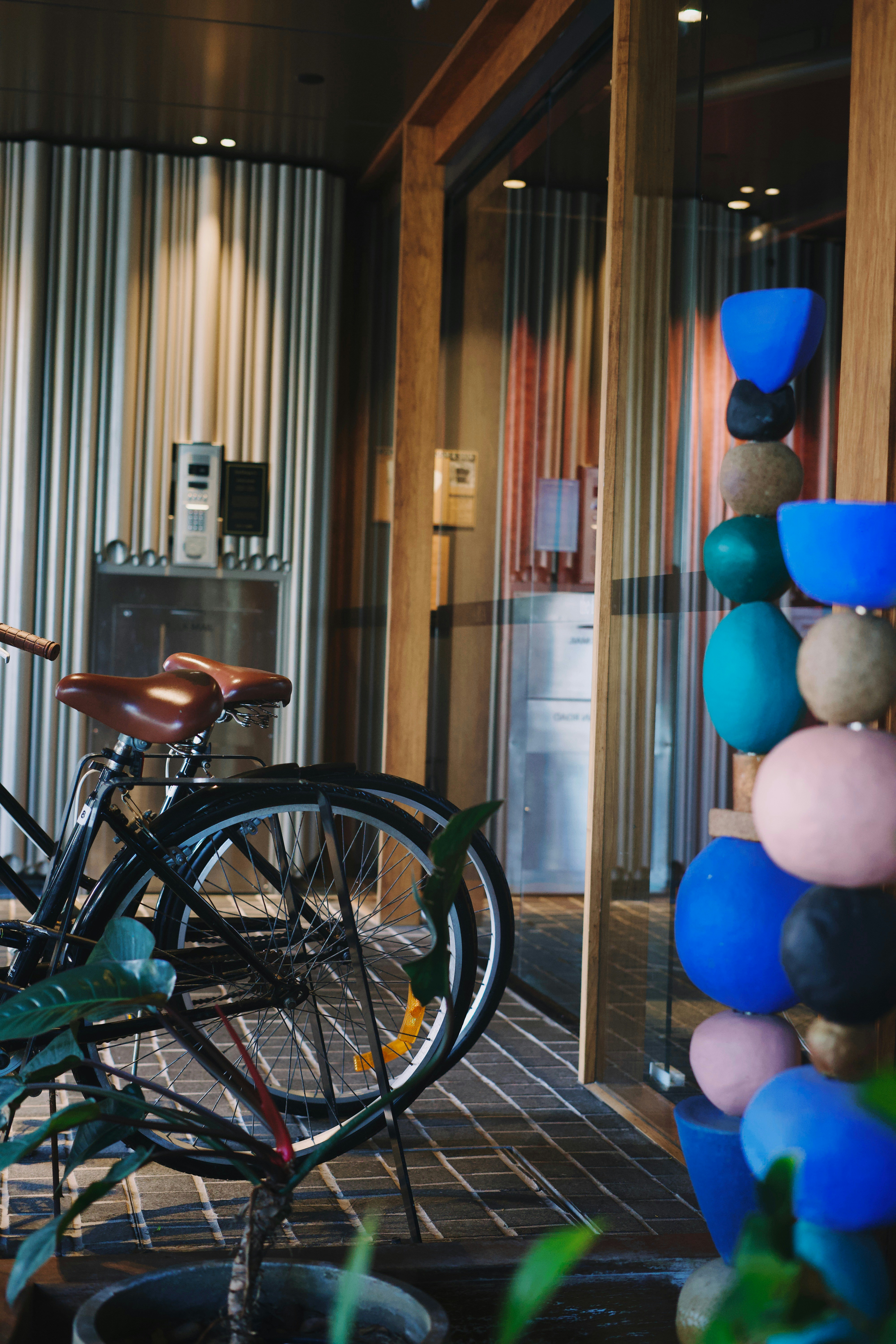 Bicycle by Glass Door Framed by a Tower of Colorful Spheres