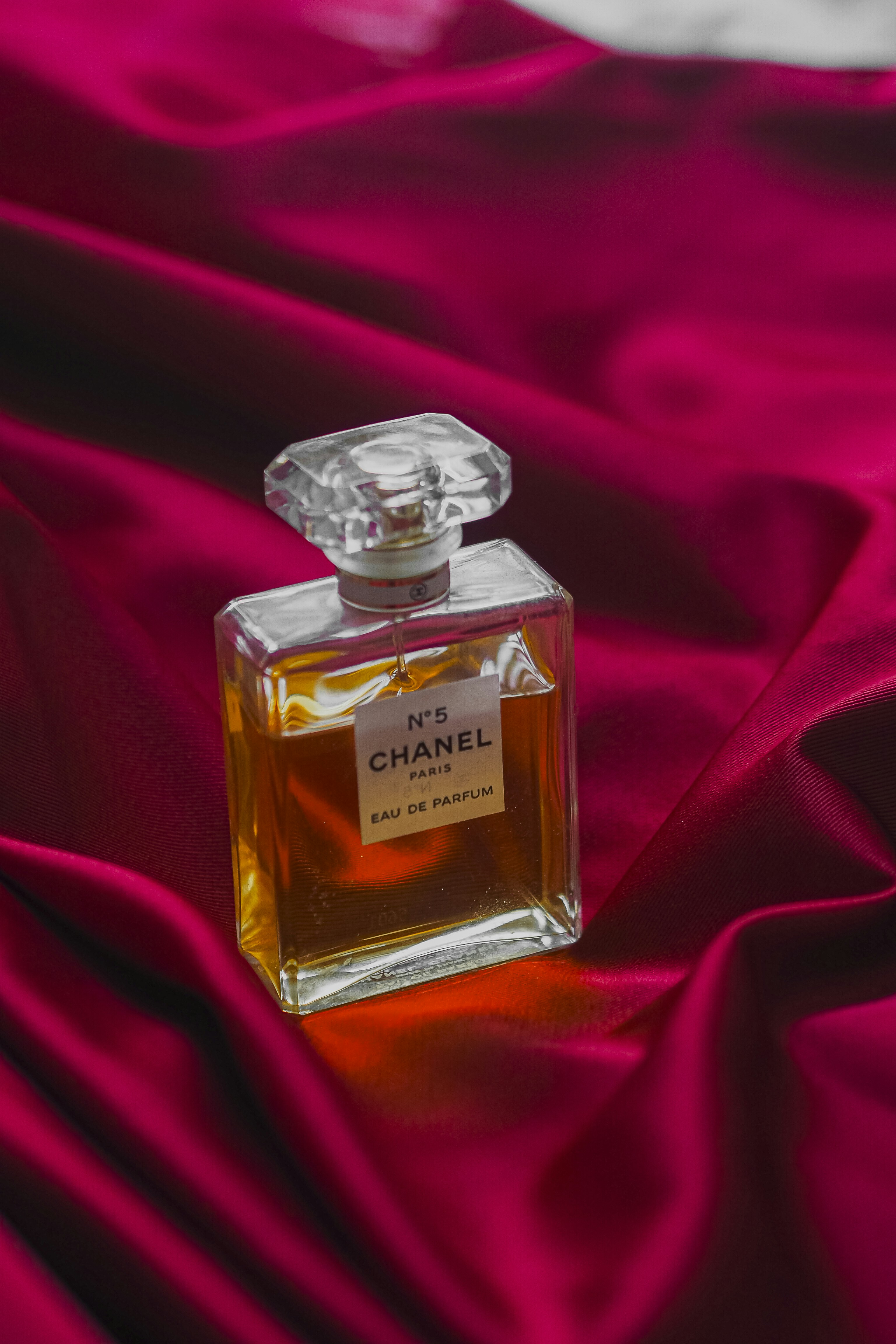 A bottle of chanel perfume sitting on a red cloth photo – Free Perfume ...