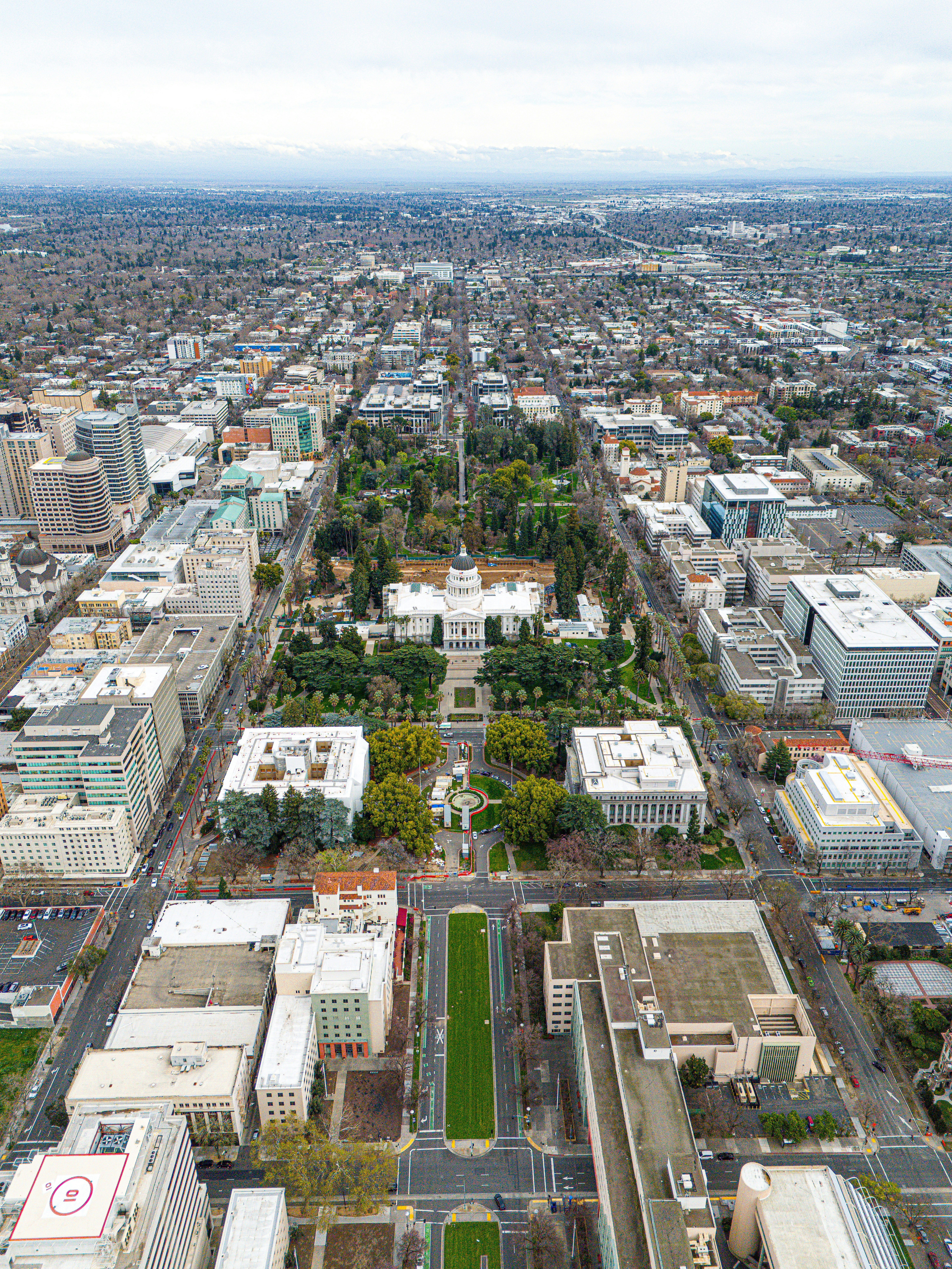 Bird's-eye view of a vibrant cityscape featuring a central park and historic architecture, showcasing urban life harmoniously intertwined with nature.