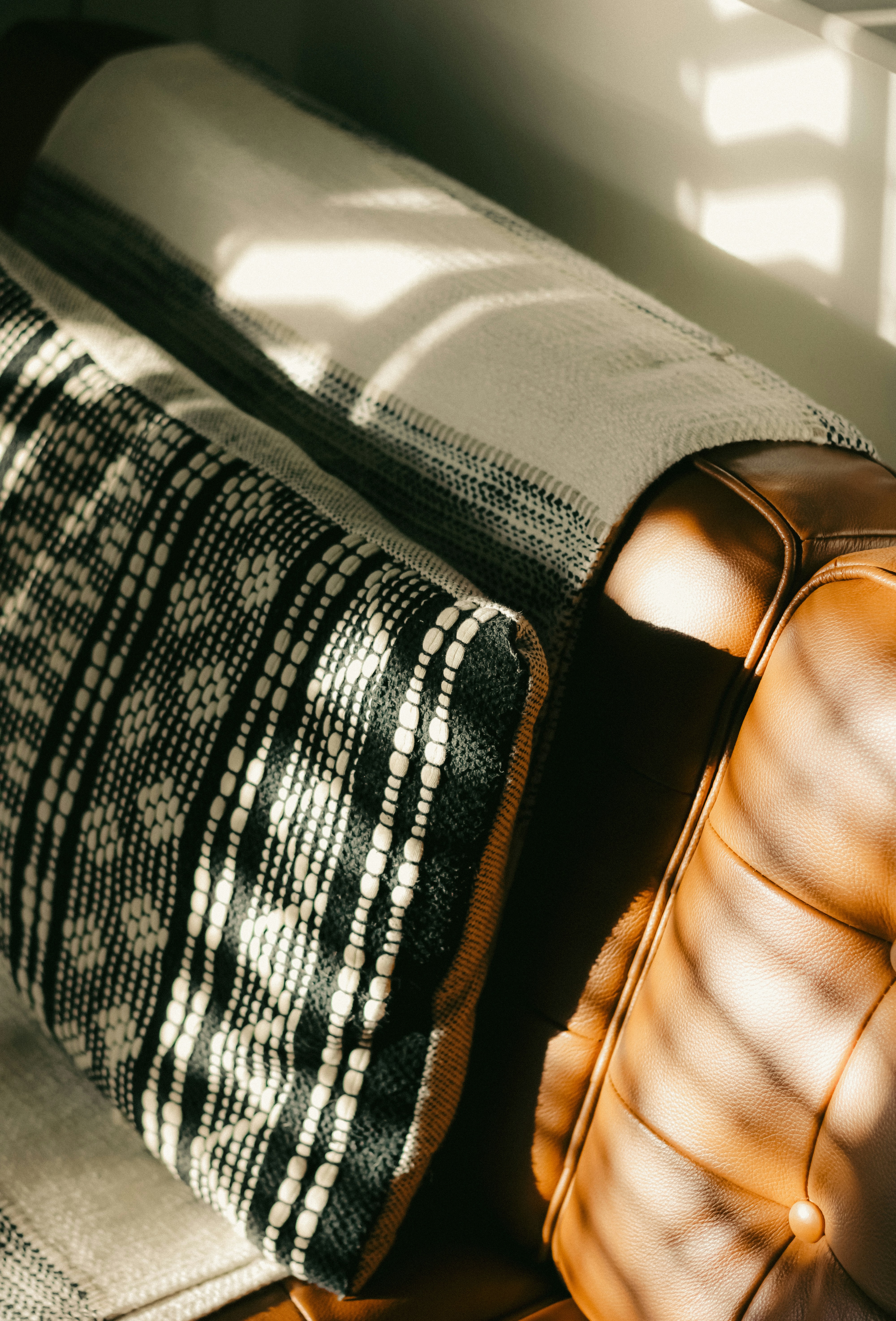 A brown leather couch sitting next to a window photo – Free Cushion ...