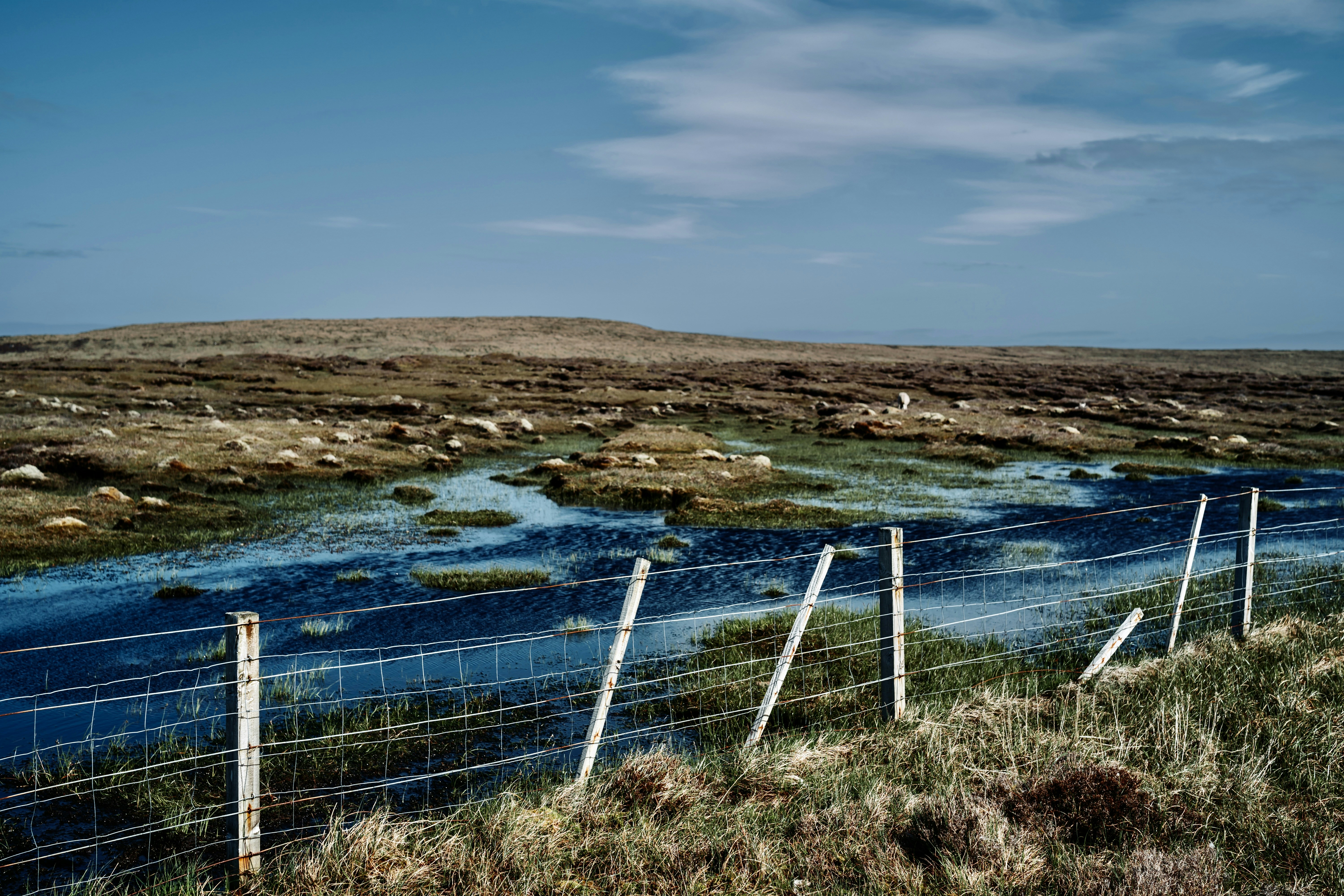 A fenced in area with a river running through it photo – Free Land ...