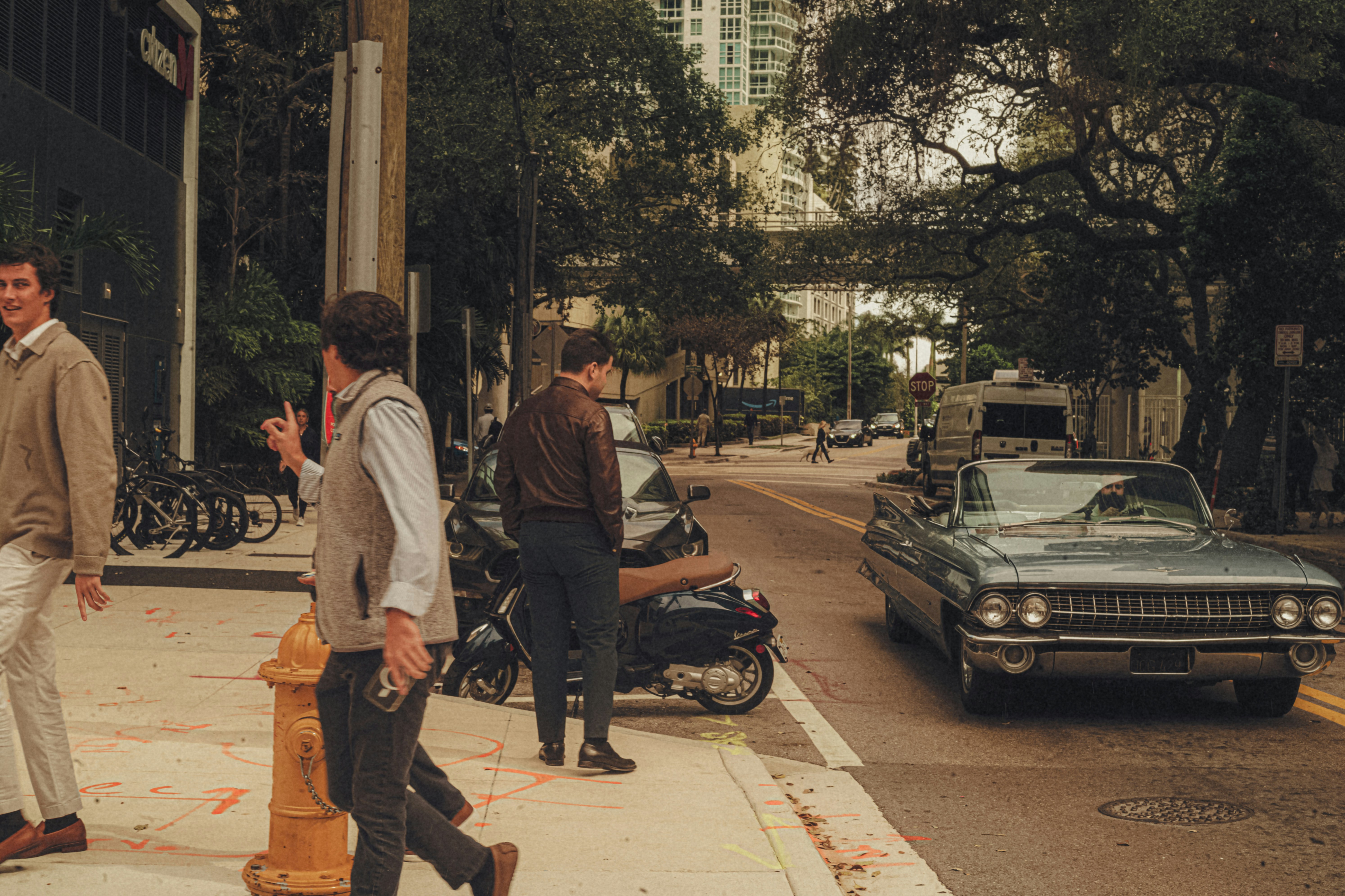 A couple of men walking across a street next to a fire hydrant photo ...