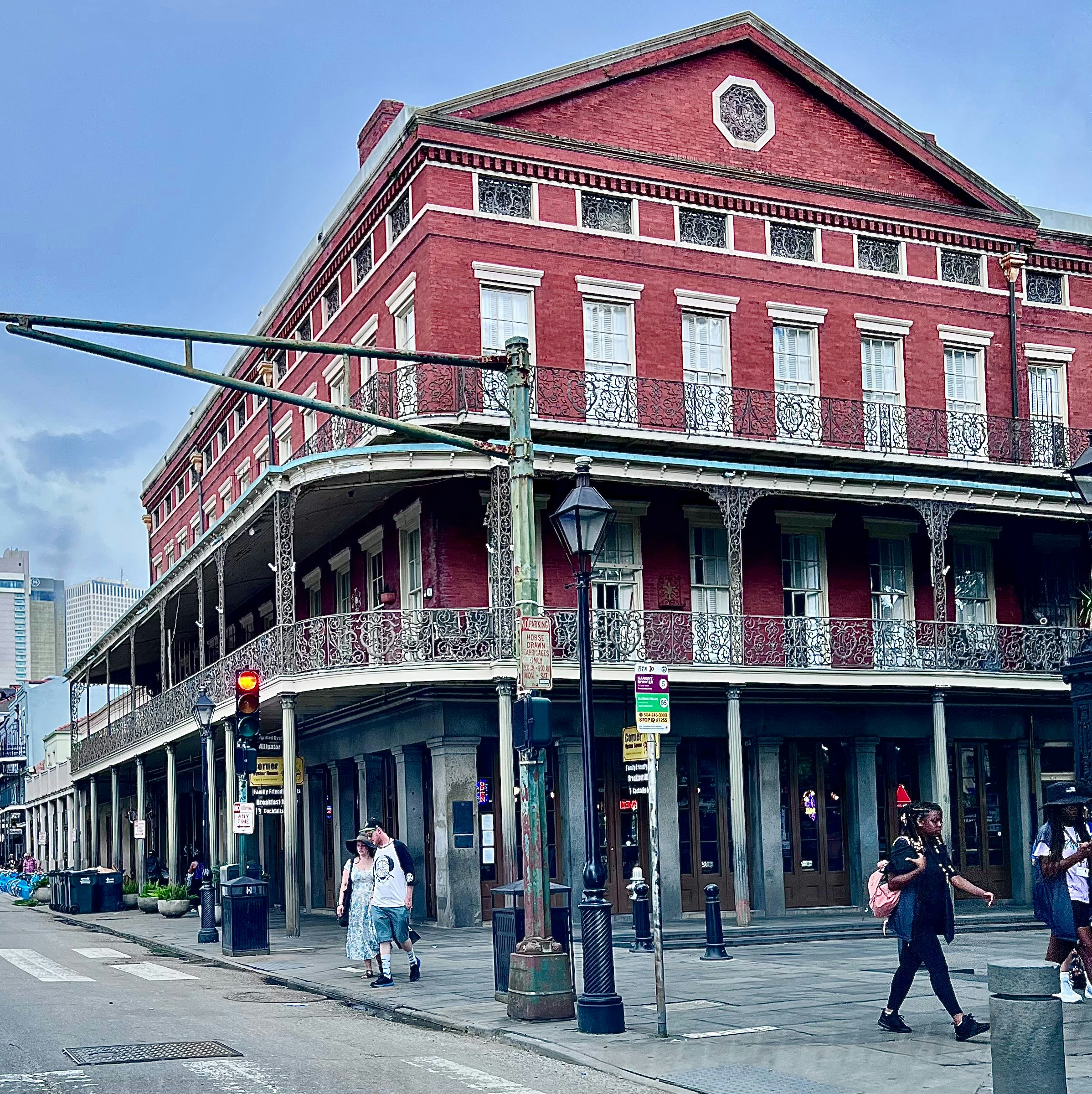 Brick-and-Iron Corner: Sunlit Veranda Elevating a Busy Street