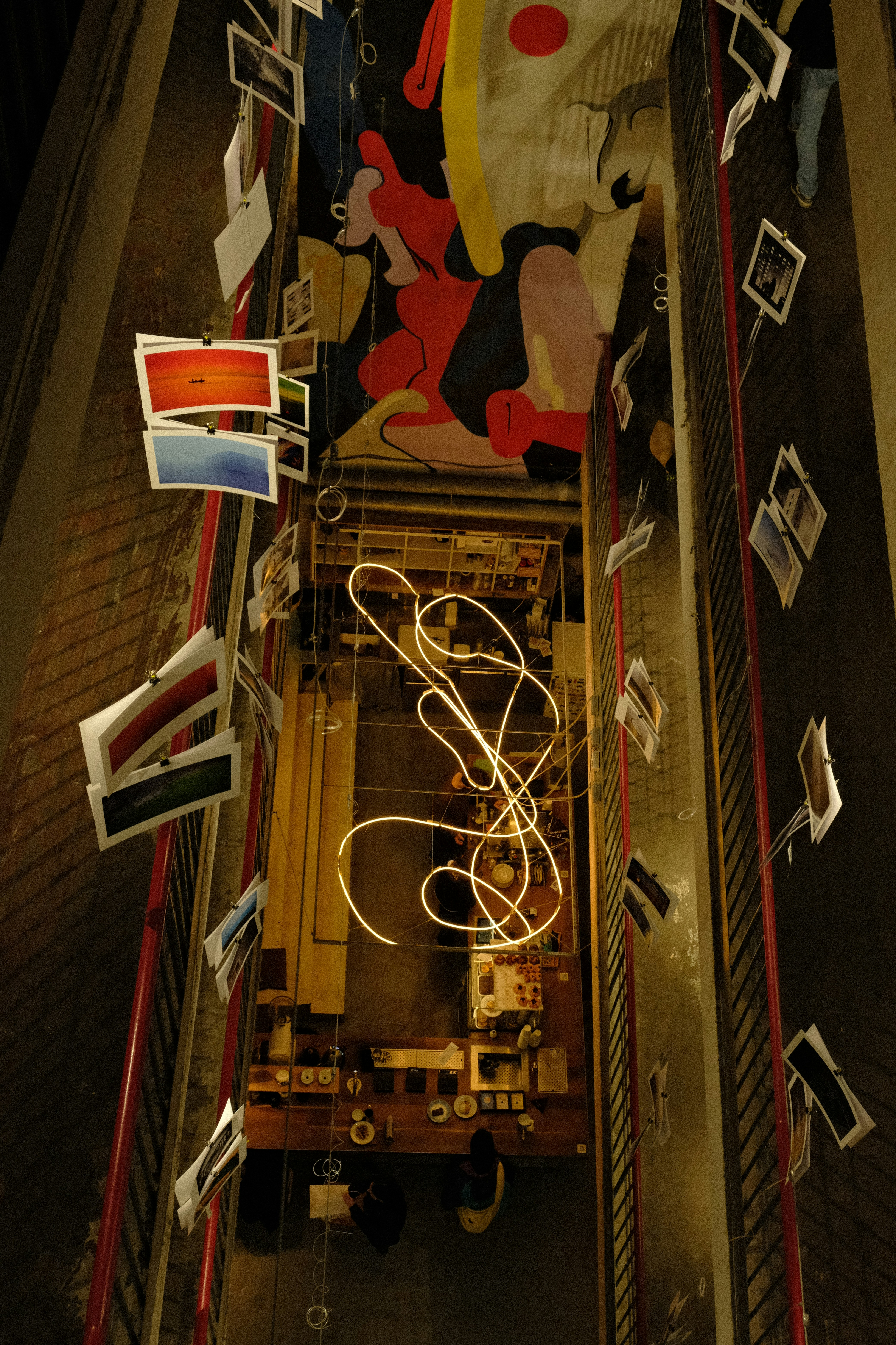 Neon Loops Over Floating Polaroids in a Brick-Walled Stairwell Gallery