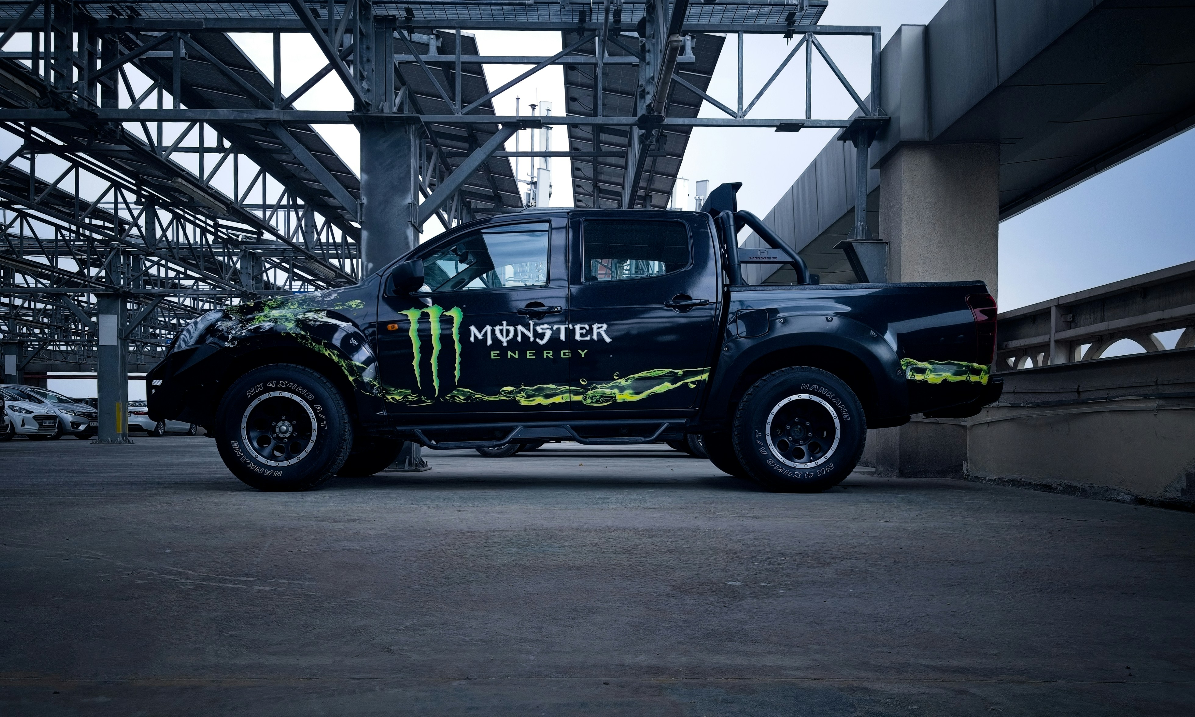 A monster truck is parked under a bridge photo – Free Black Image on ...