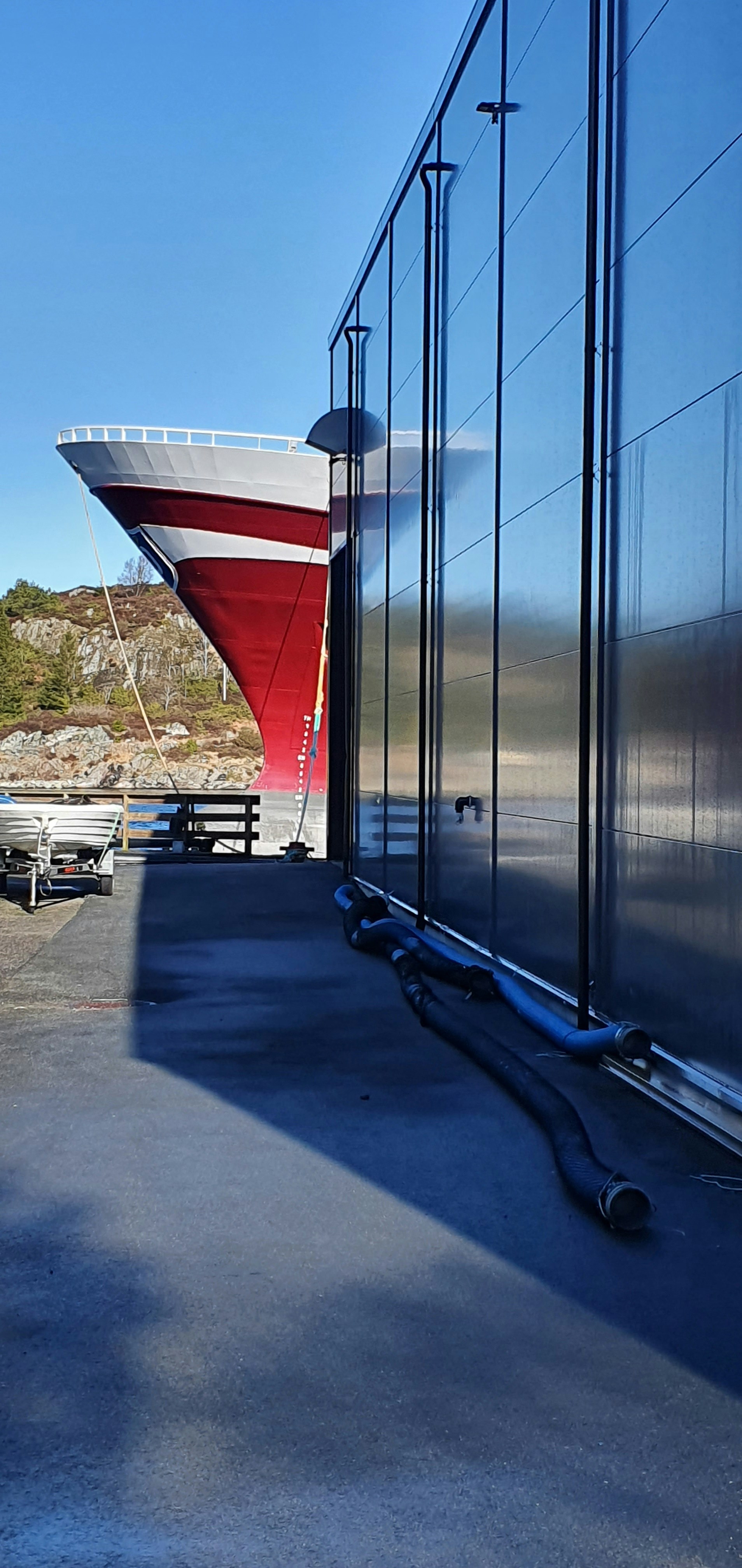Crimson Bow Rising by a Glass-Clad Dock